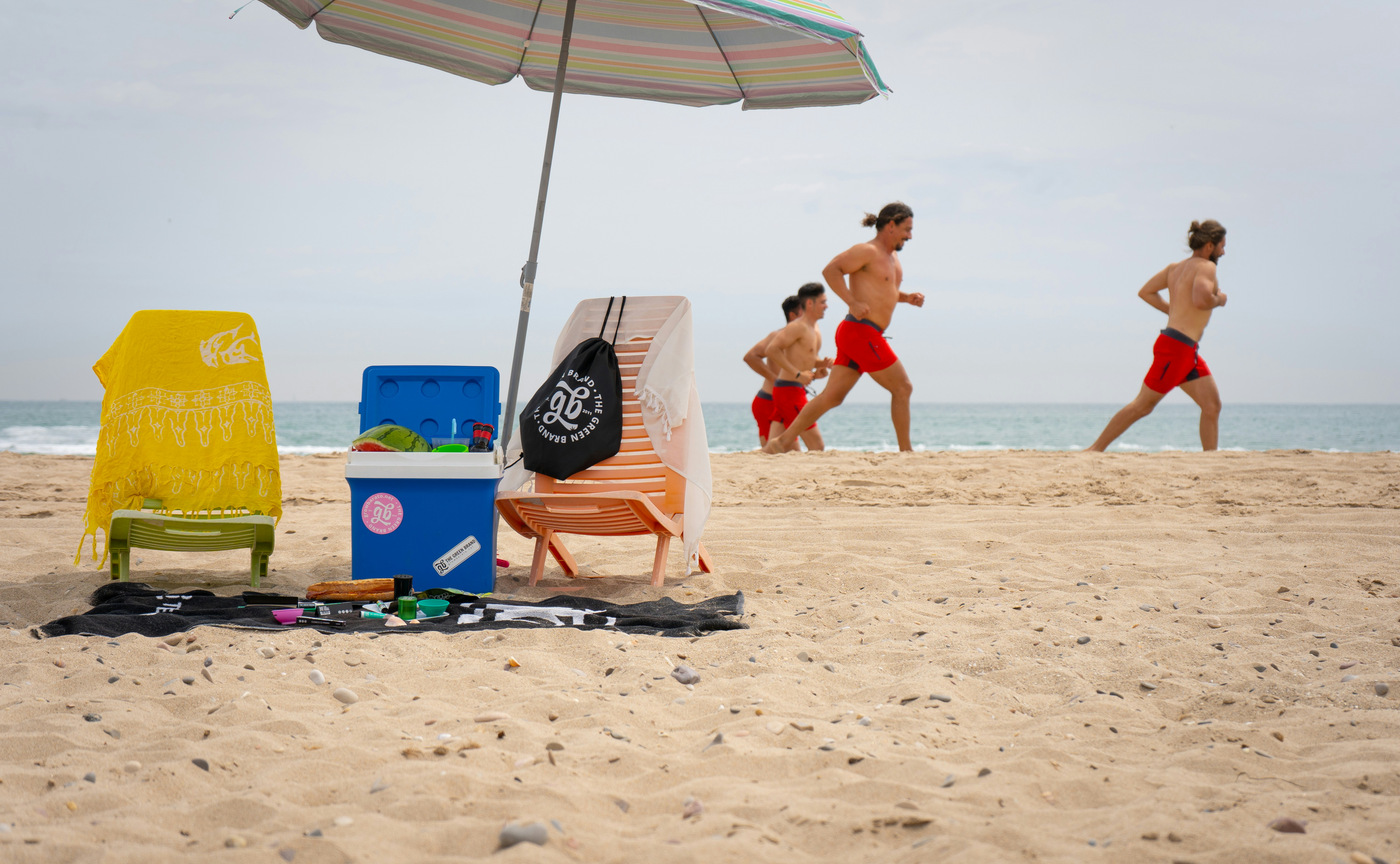 Beachside Coexistence: Lifeguard Gear and Runners on Sunlit Shore