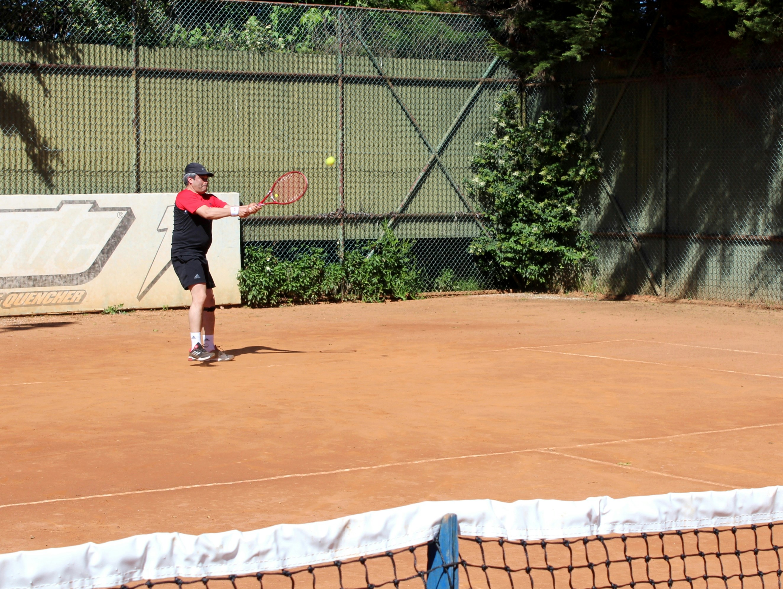 Serve Ready: Tennis Shot in a Sunlit Clay Court