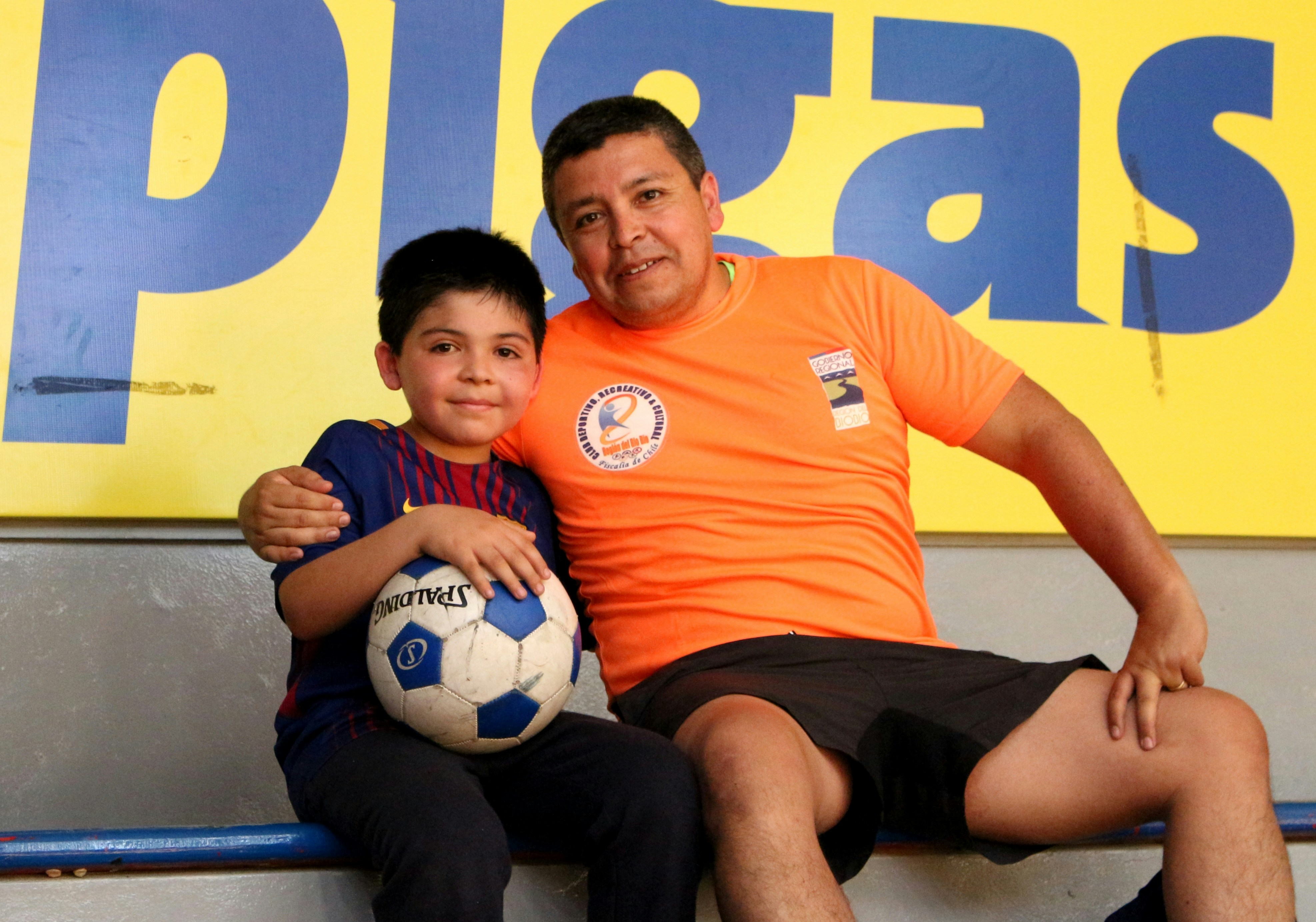 Two Generations, One Bench: A Shared Moment at the Football Field