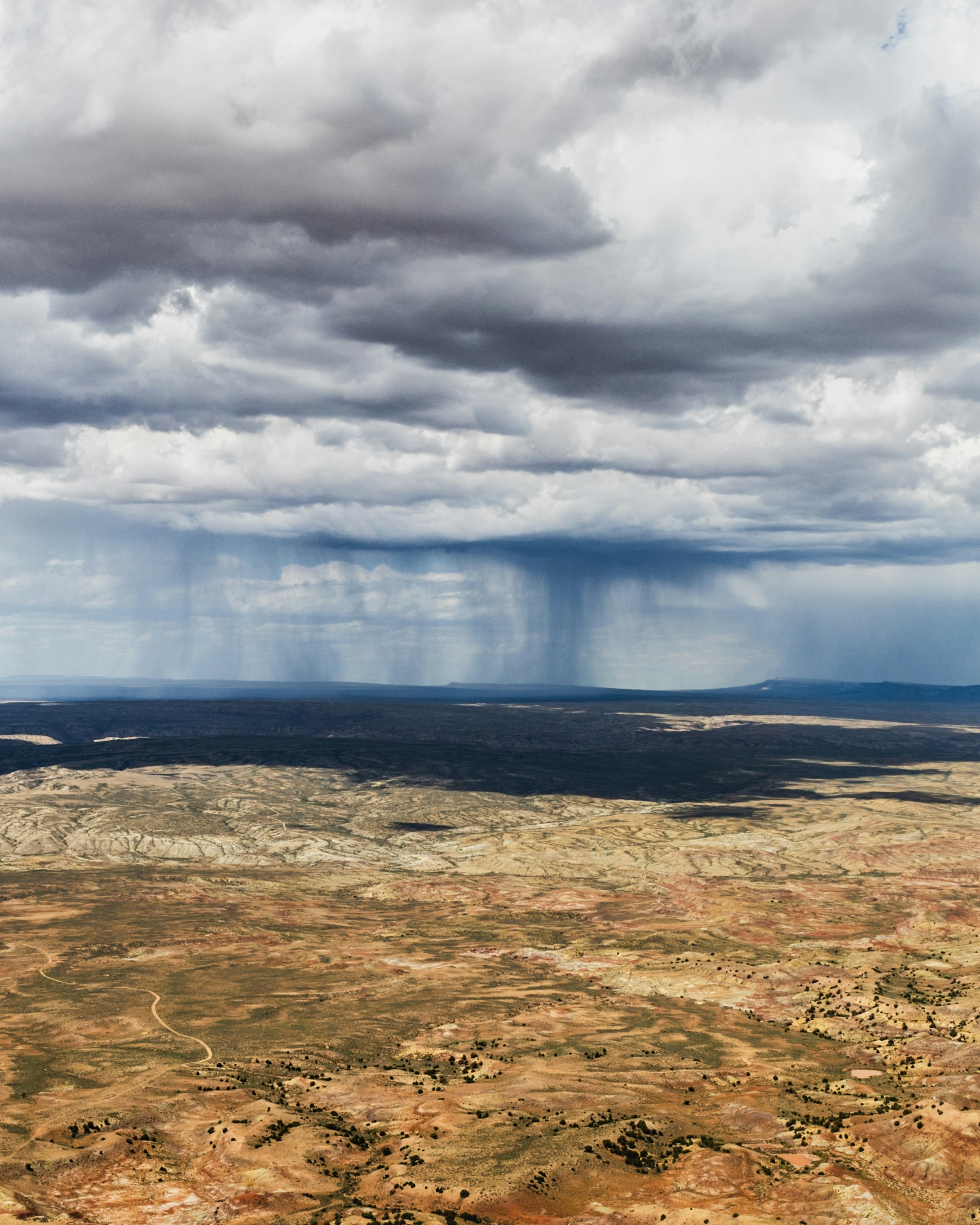 RainfallStreaks Over Desert Expanse: A Distant Curtain of Storm