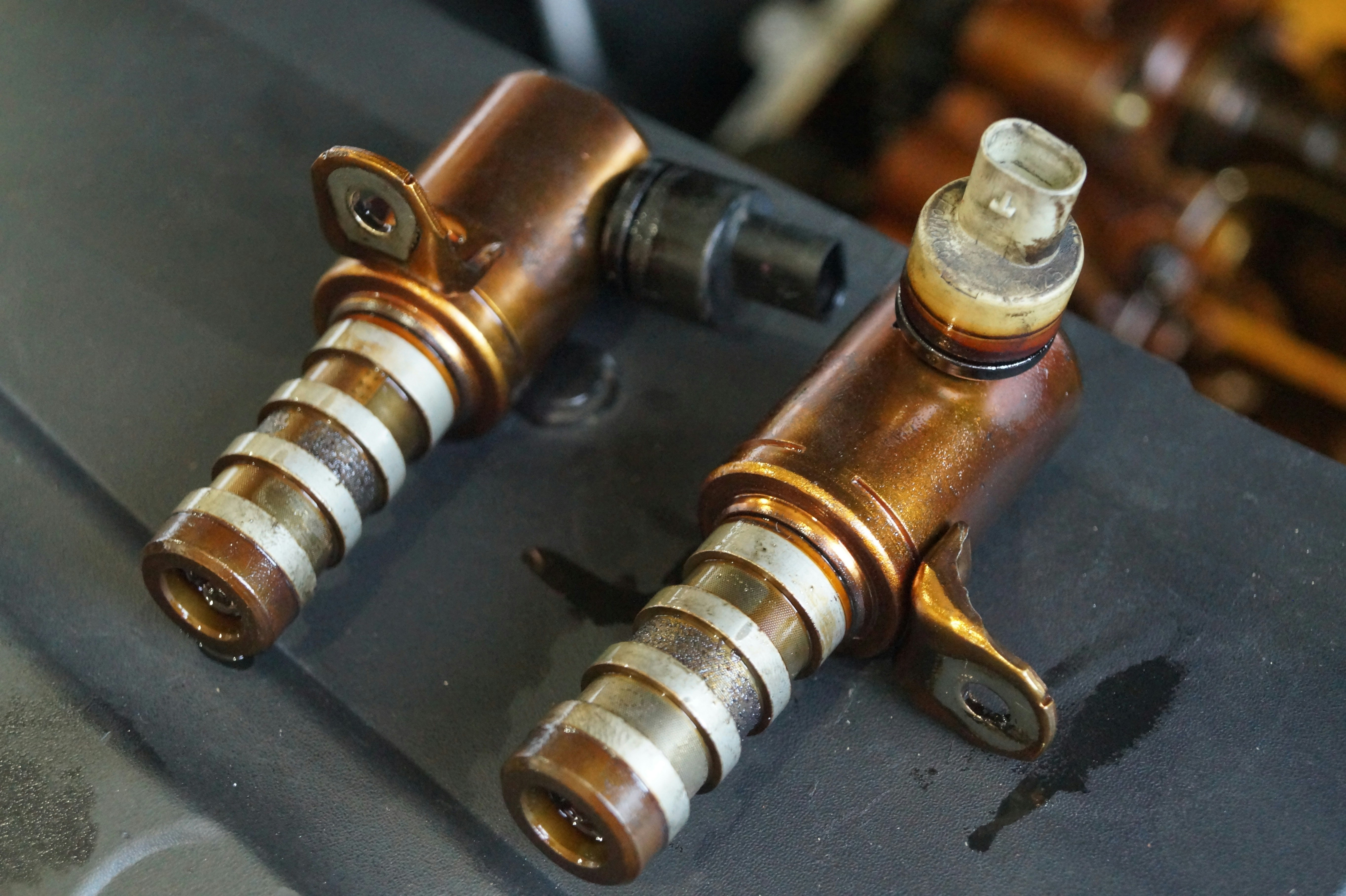 Two copper bolt assemblies resting on a dark surface