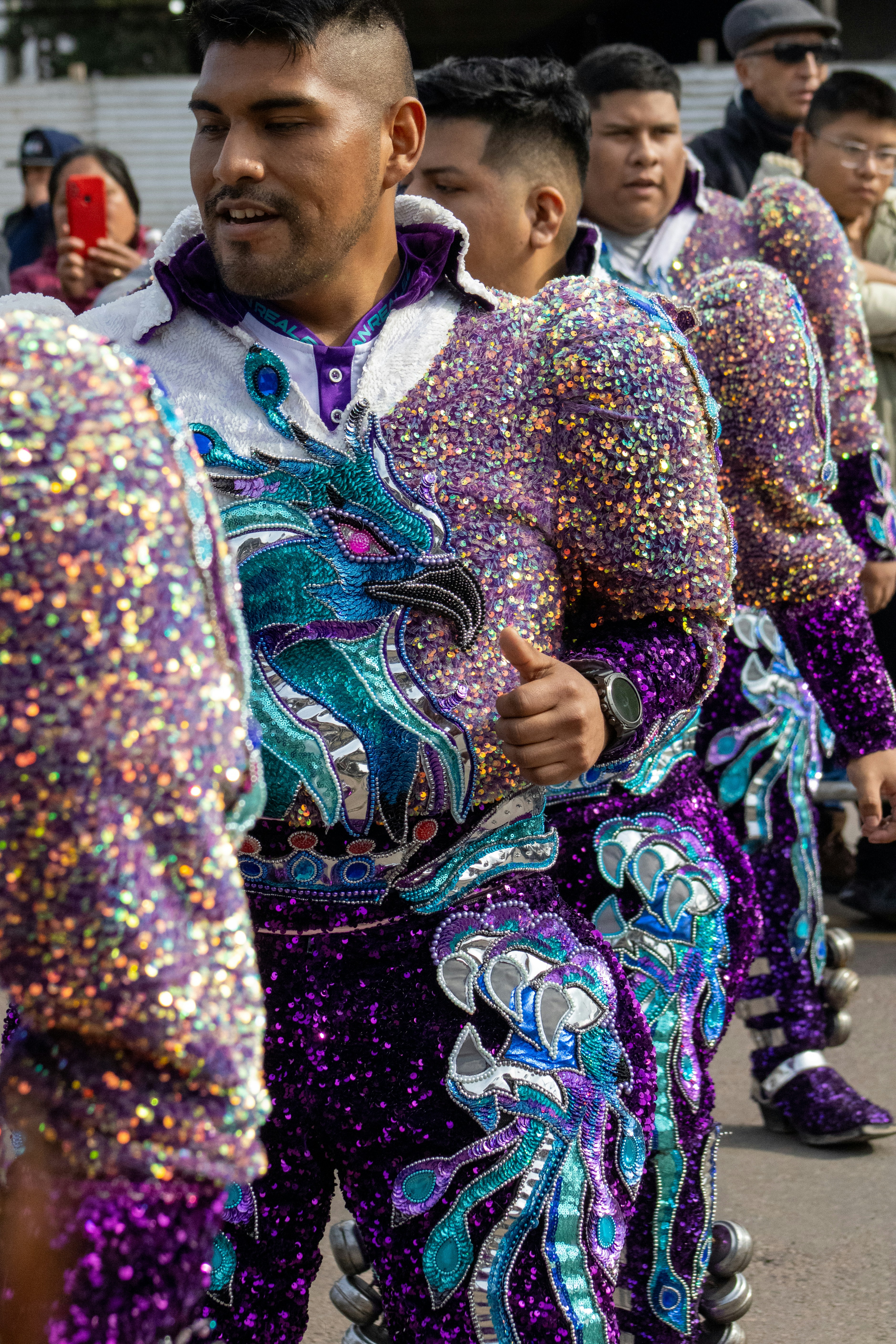 Sequined procession: a row of color-drenched performers marching in unison