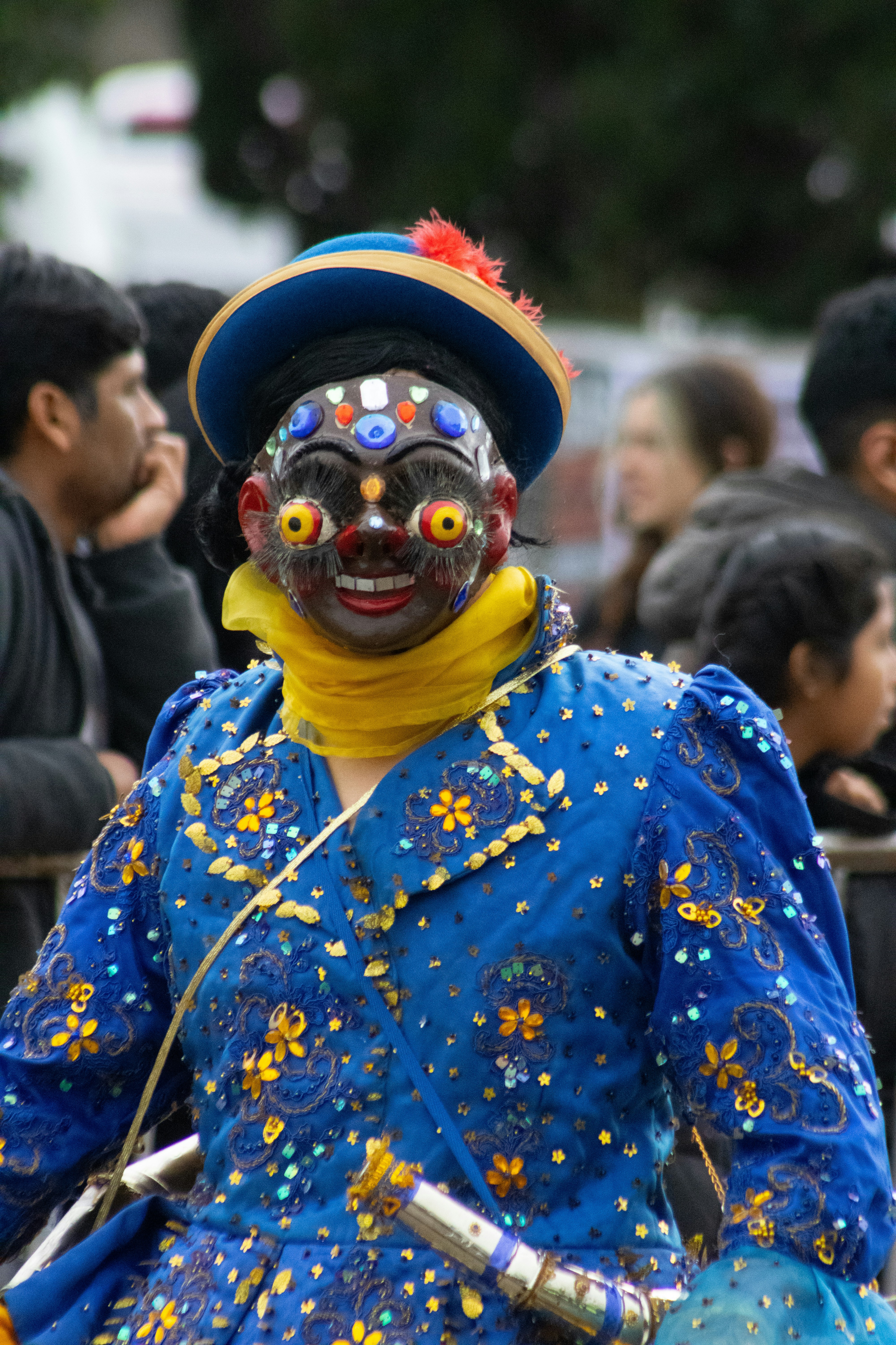 Masked Performer in a Blue Embroidered Suit at a Crowded Event
