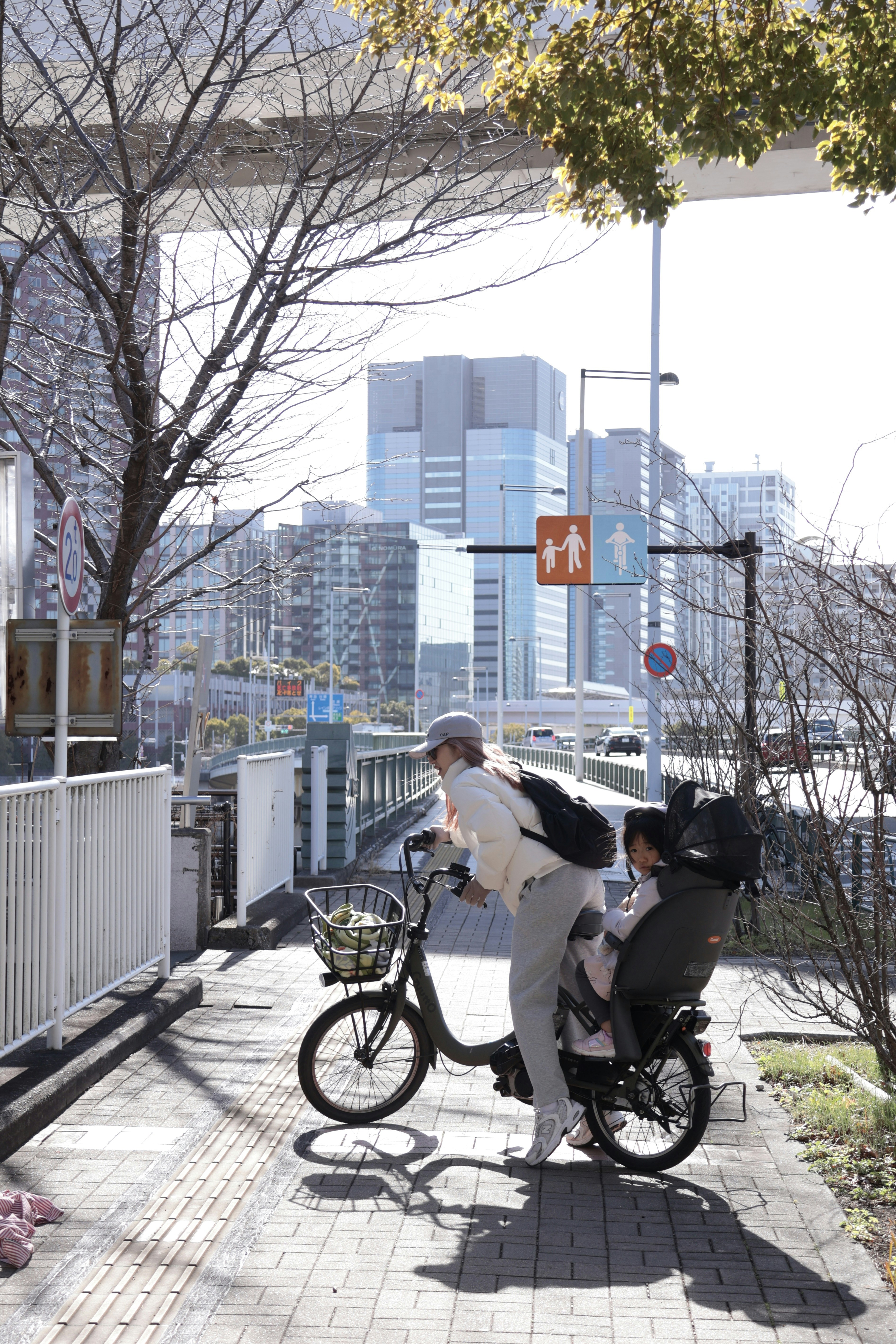 Pedal Push: A Mother and Child on an Urban Biking Scene