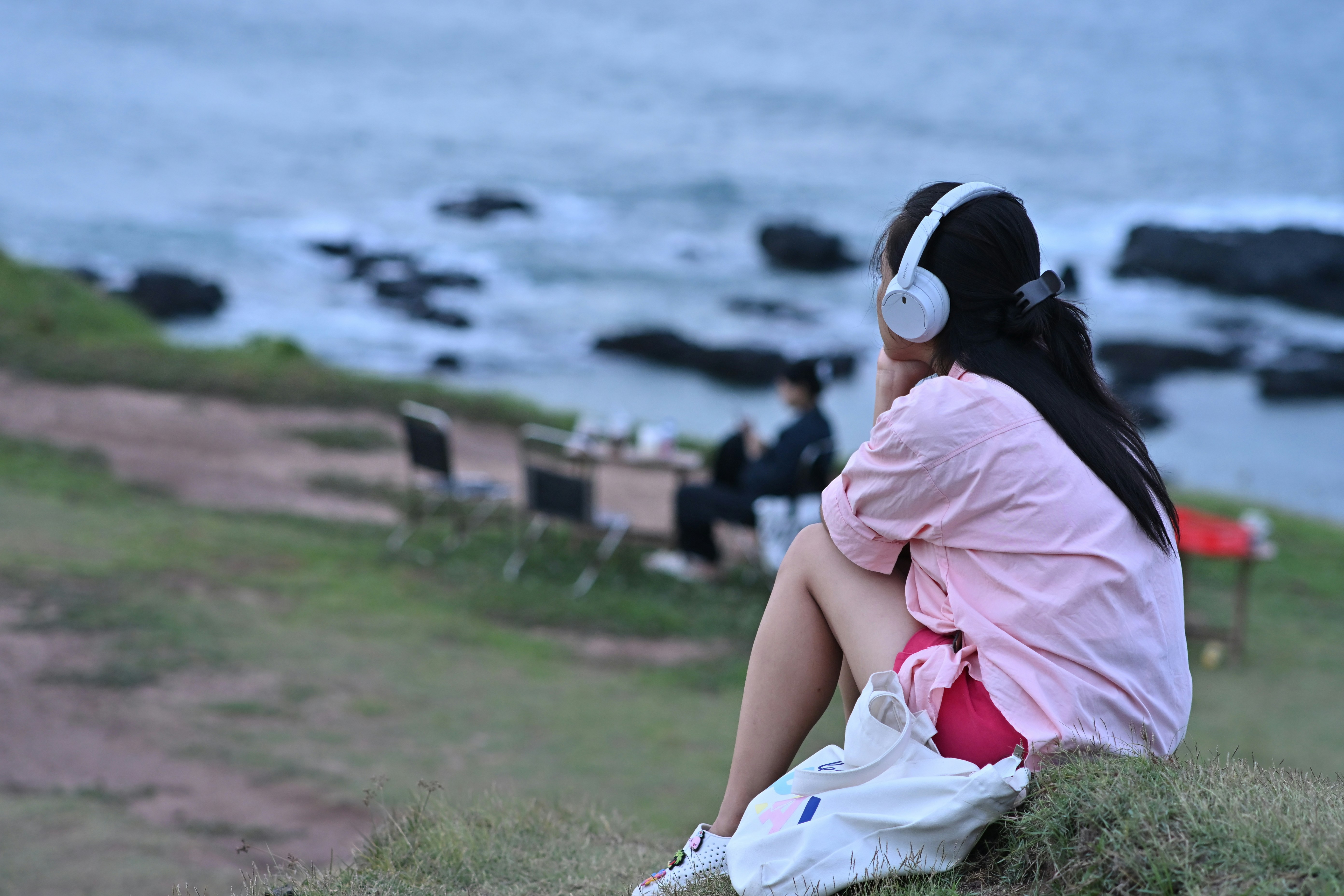 Quiet Shoreline Reverie: A Girl with Headphones at Dusk