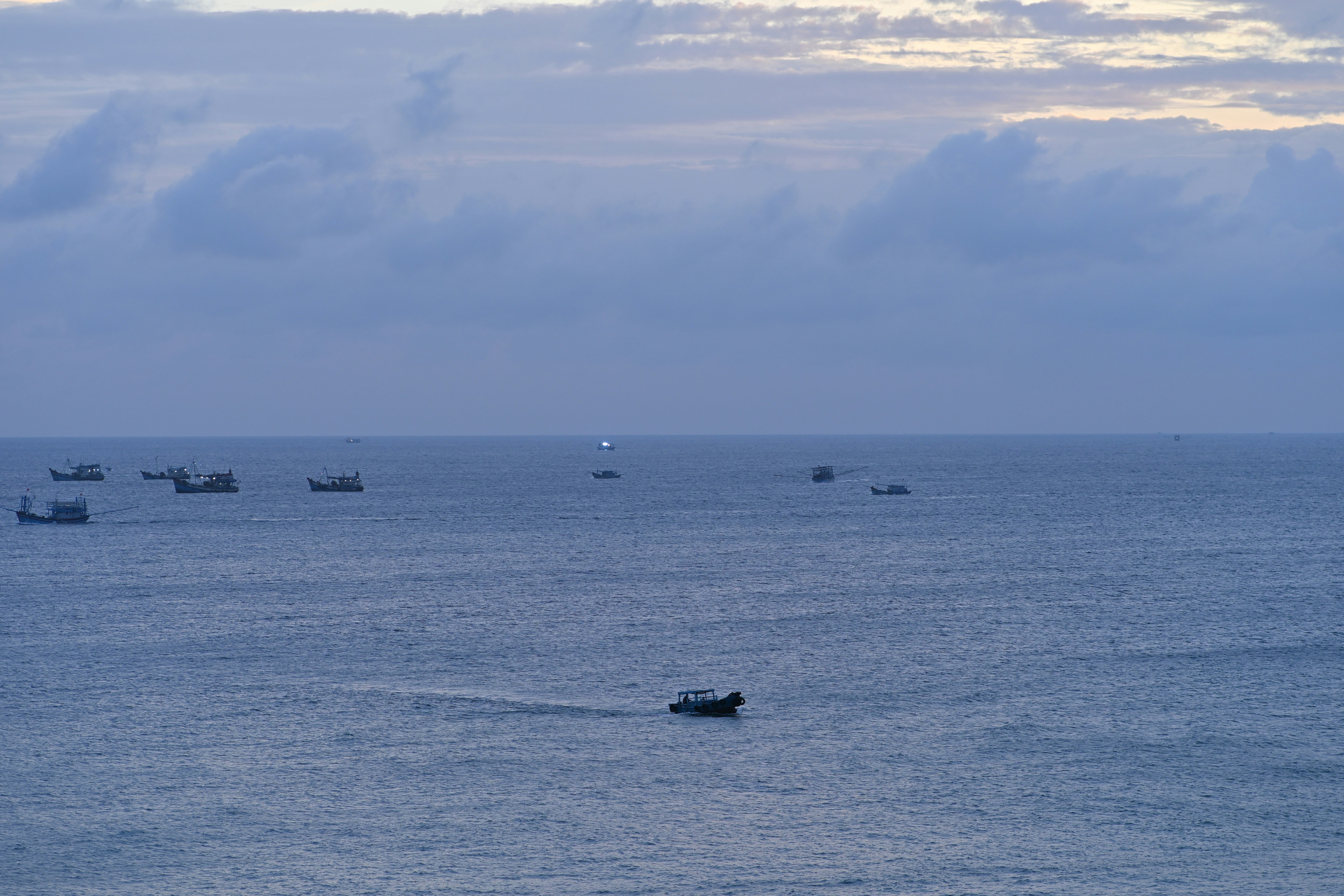 Rim of the Horizon: Boats Scattered Across a Calm Sea