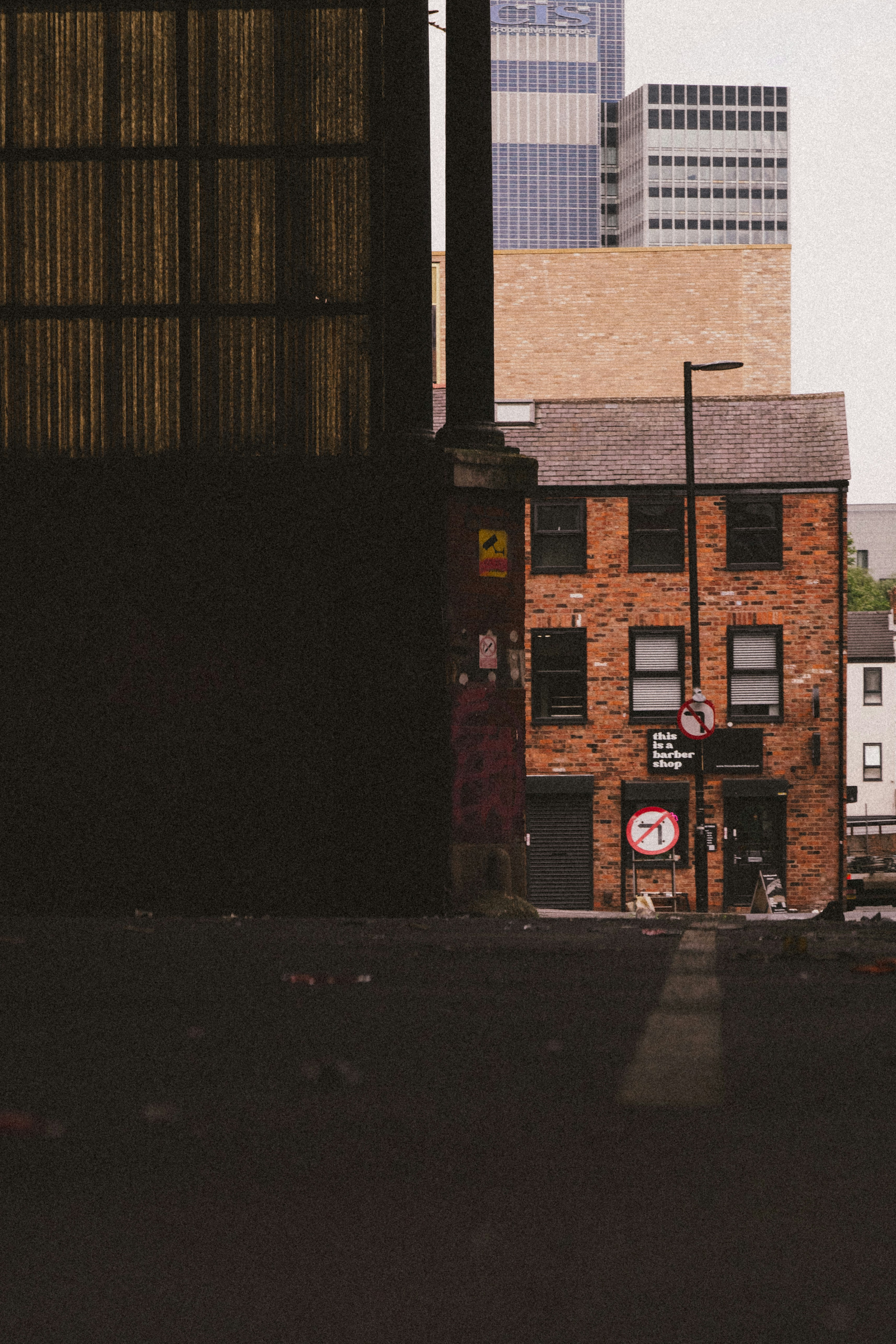 Brick Street Edge at Dusk: A Narrow View from Between Structures