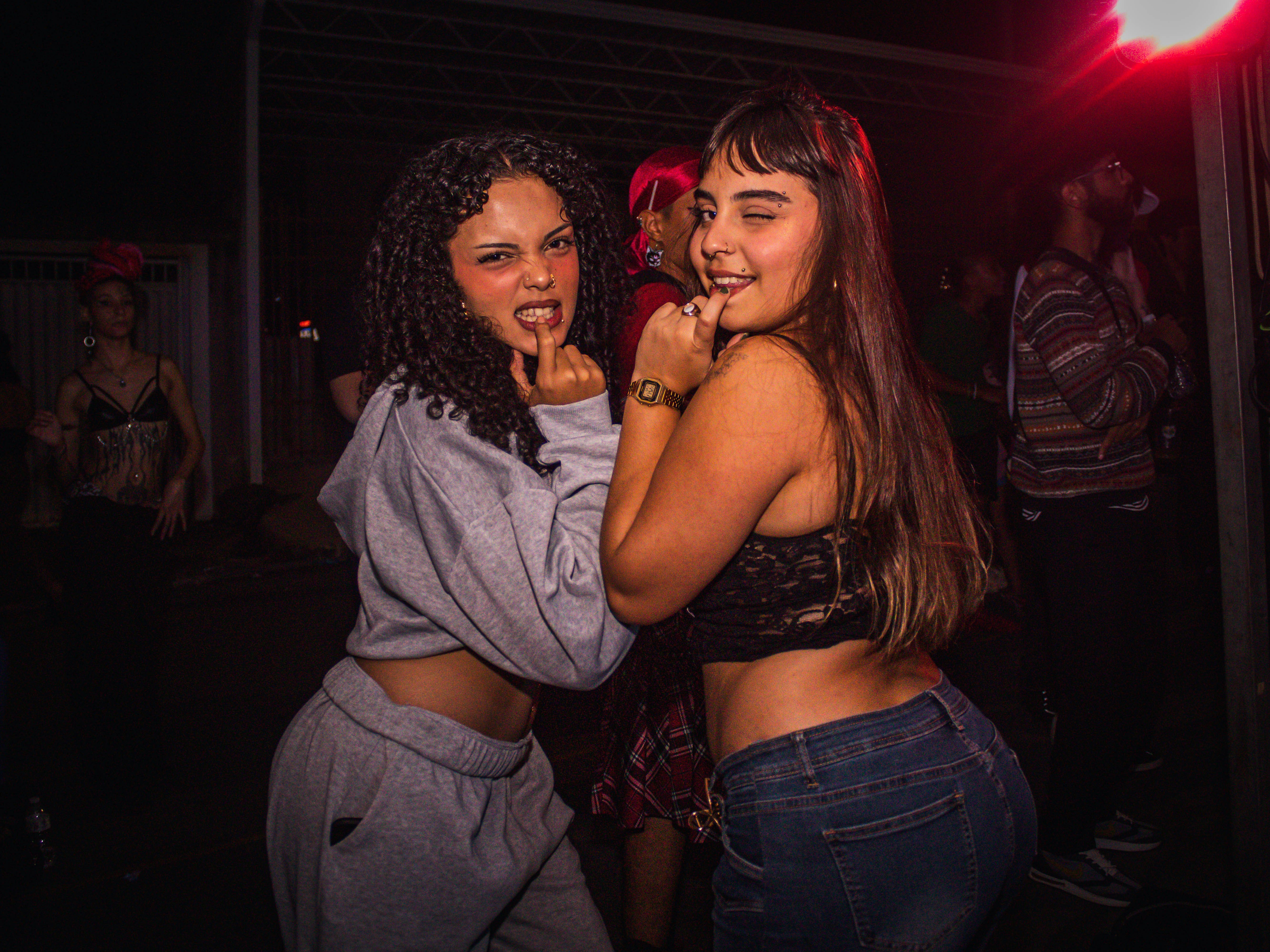 Midnight Pulse: Two Friends Playful Pose Under Club Lights