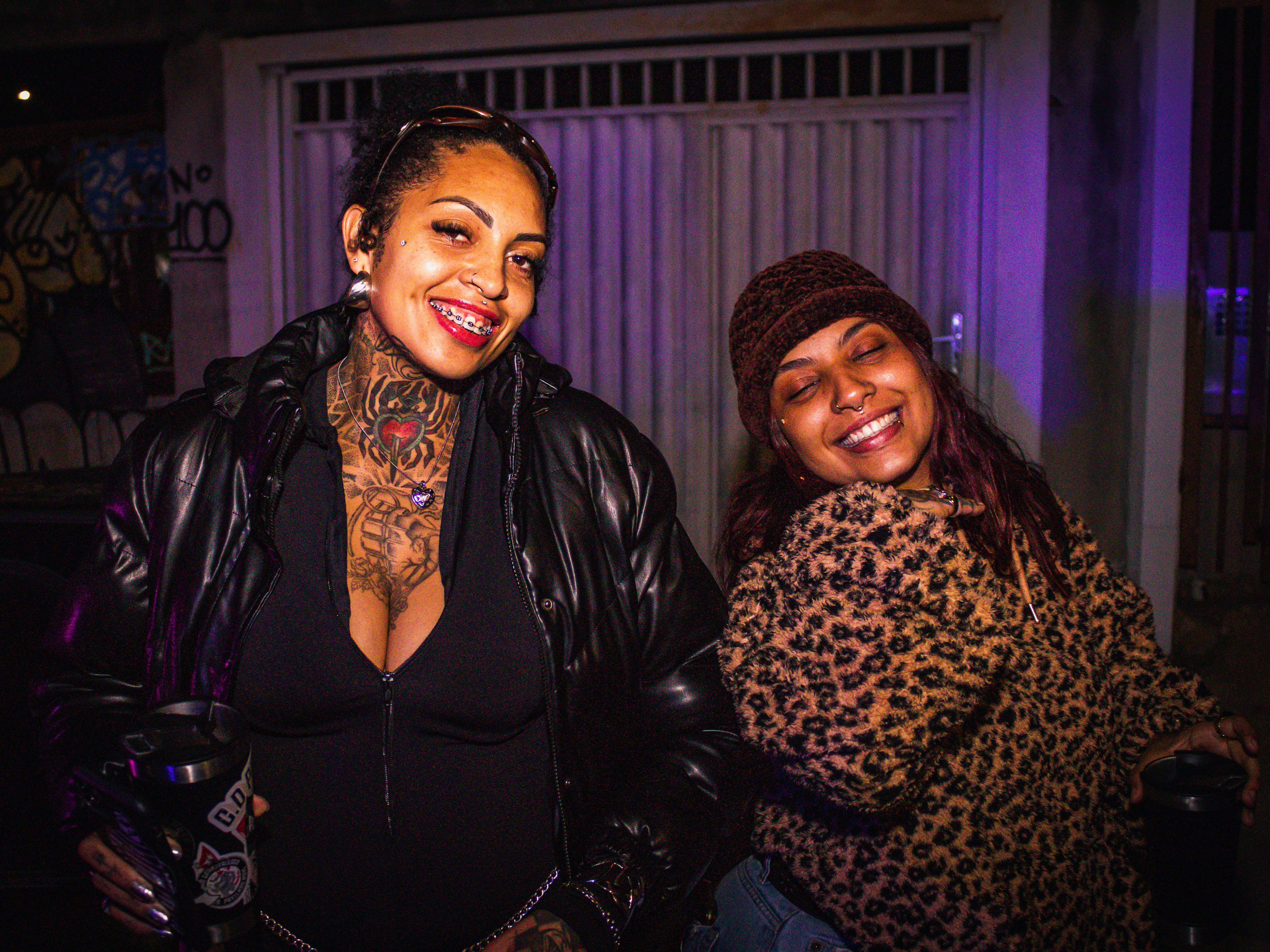 Two radiant smiles under neon glow at midnight street party