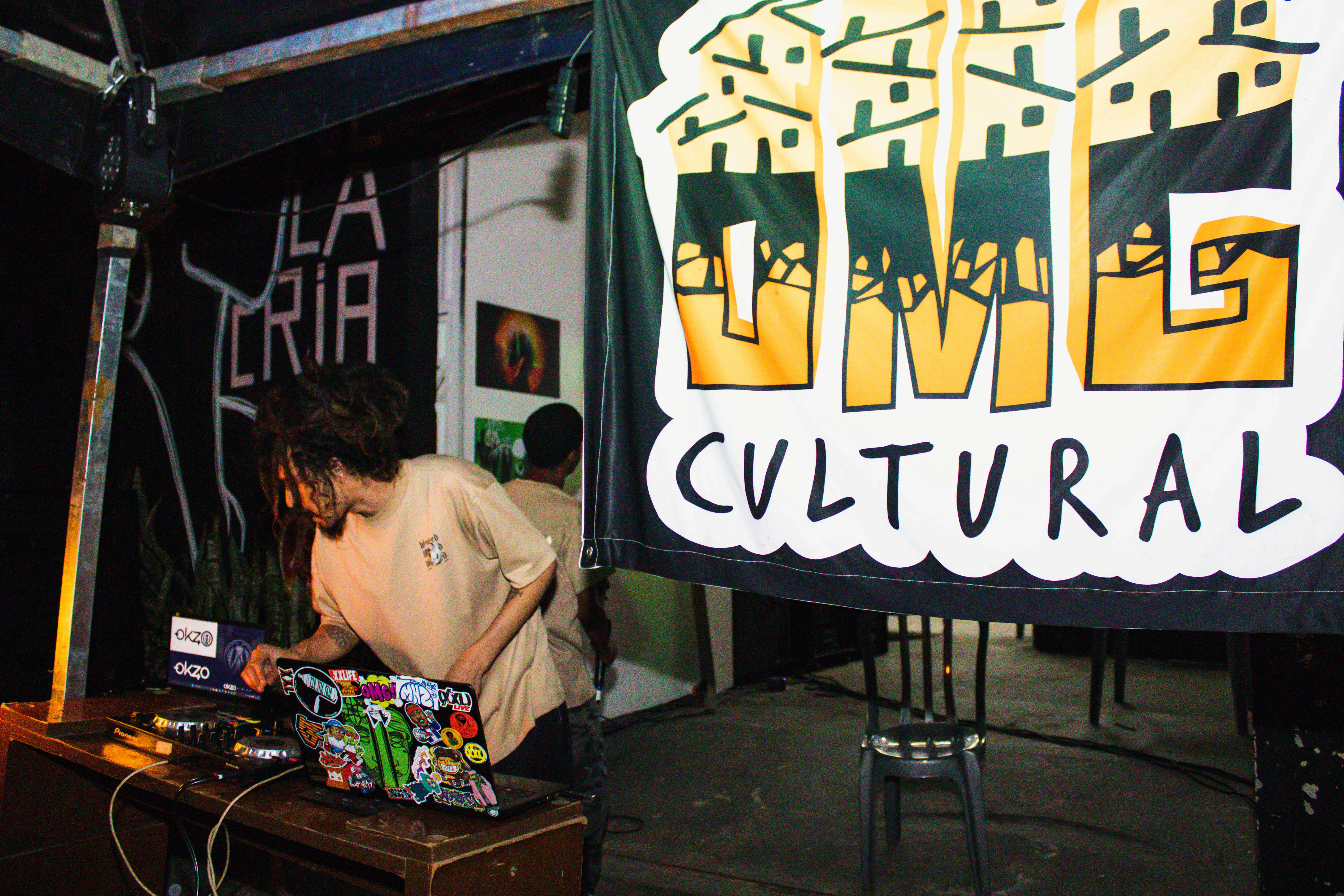 DJ Booth Under a Cultural Banner at an Indoor Event