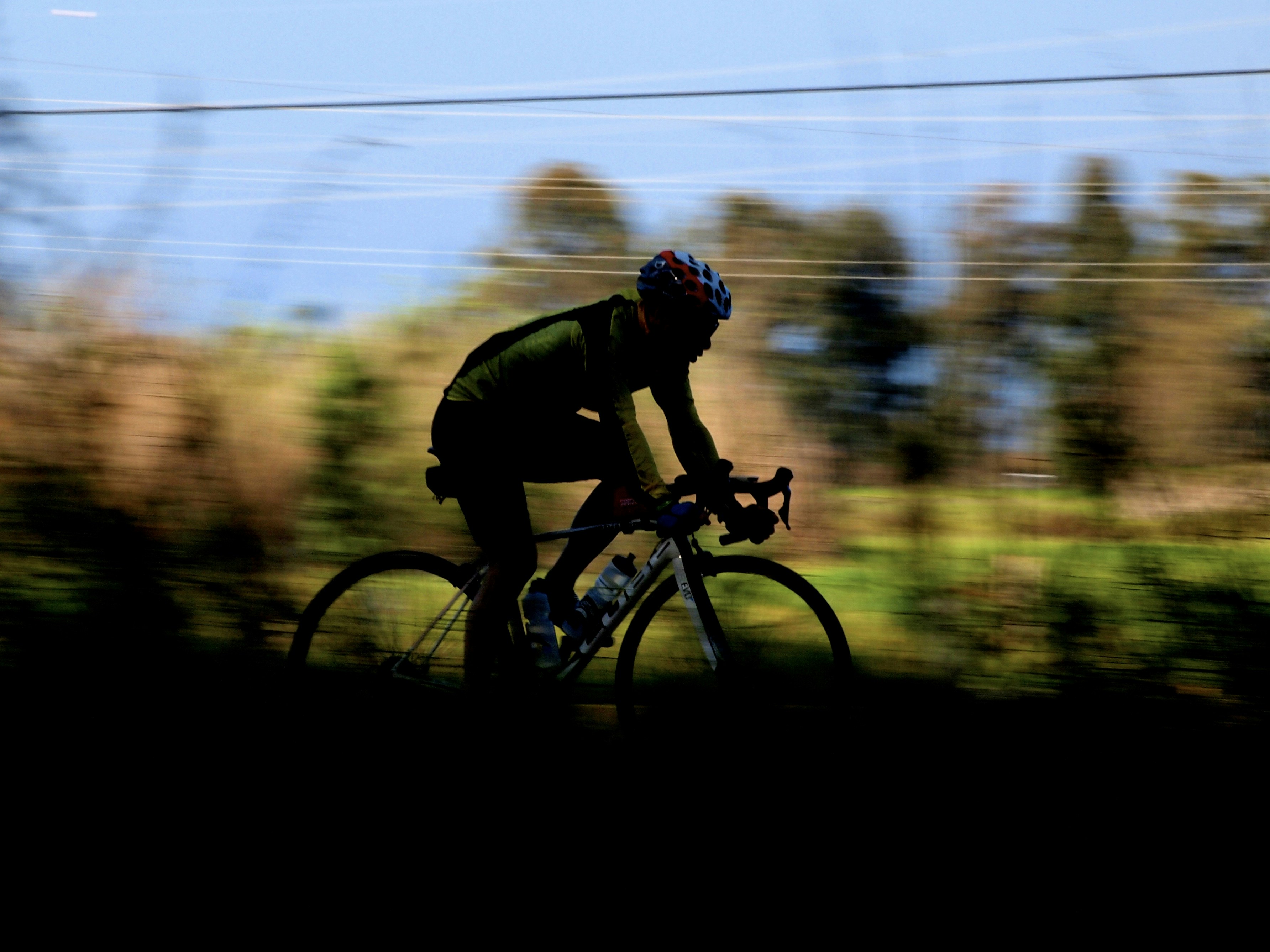 Motion in silhouette: cyclist cuts through blur at golden hour