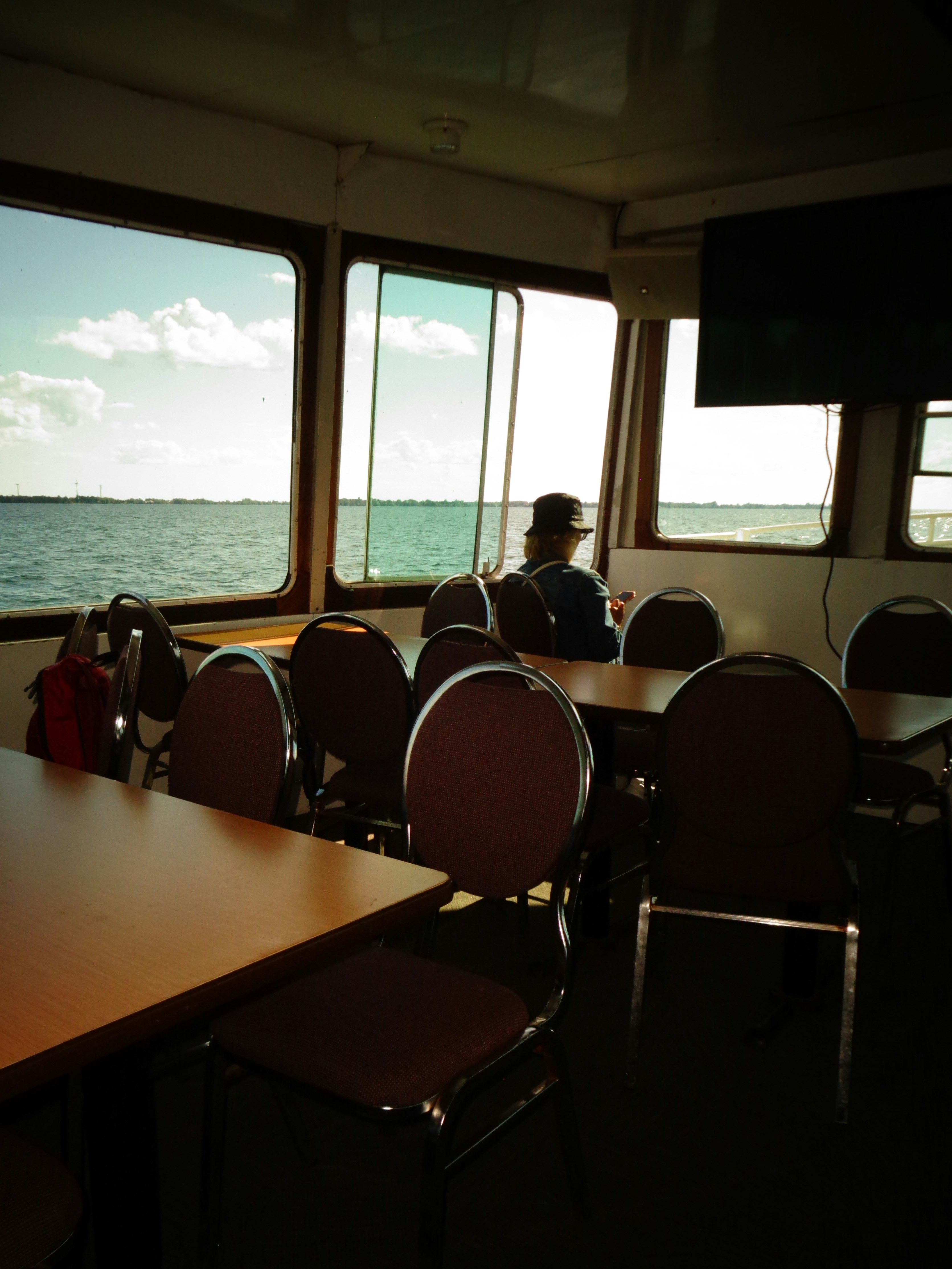 Sunlit Sea View through a Quiet Ferry Interior