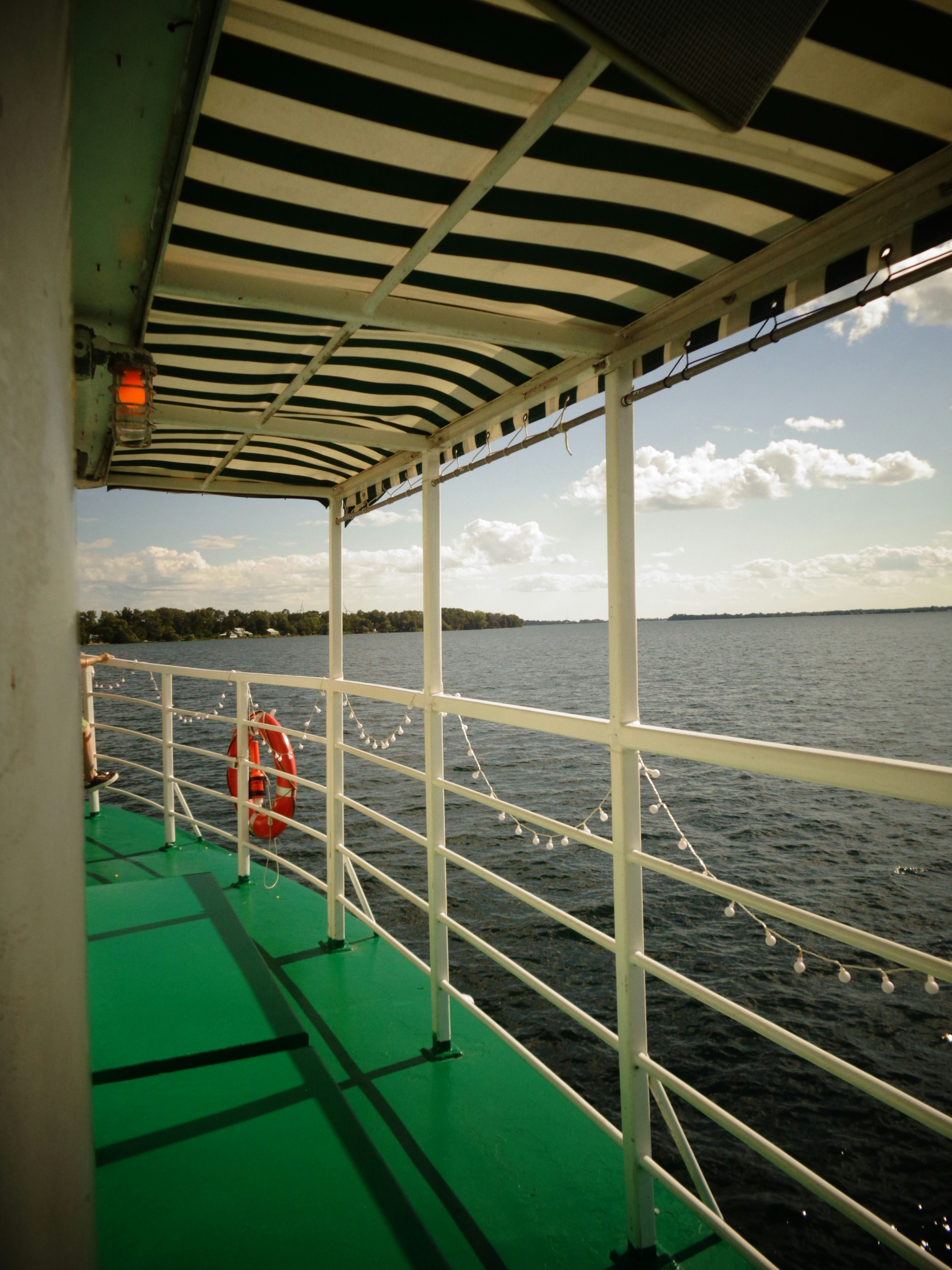 Sunlit Deck Afloat: Railing Lines and Horizon on a Quiet Sea
