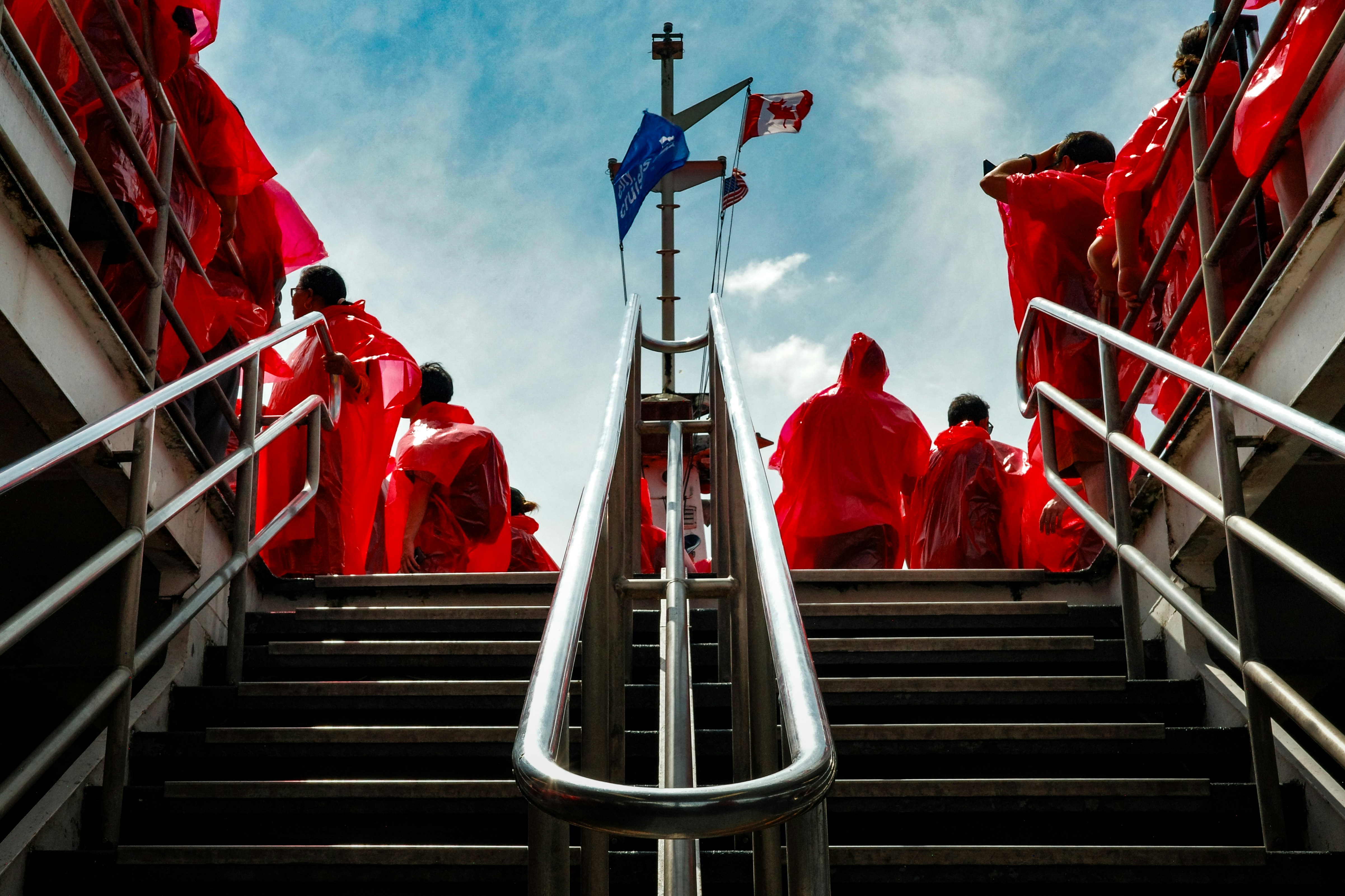 Red-cloaked ascent: symmetry and cadence on a sunlit stairway