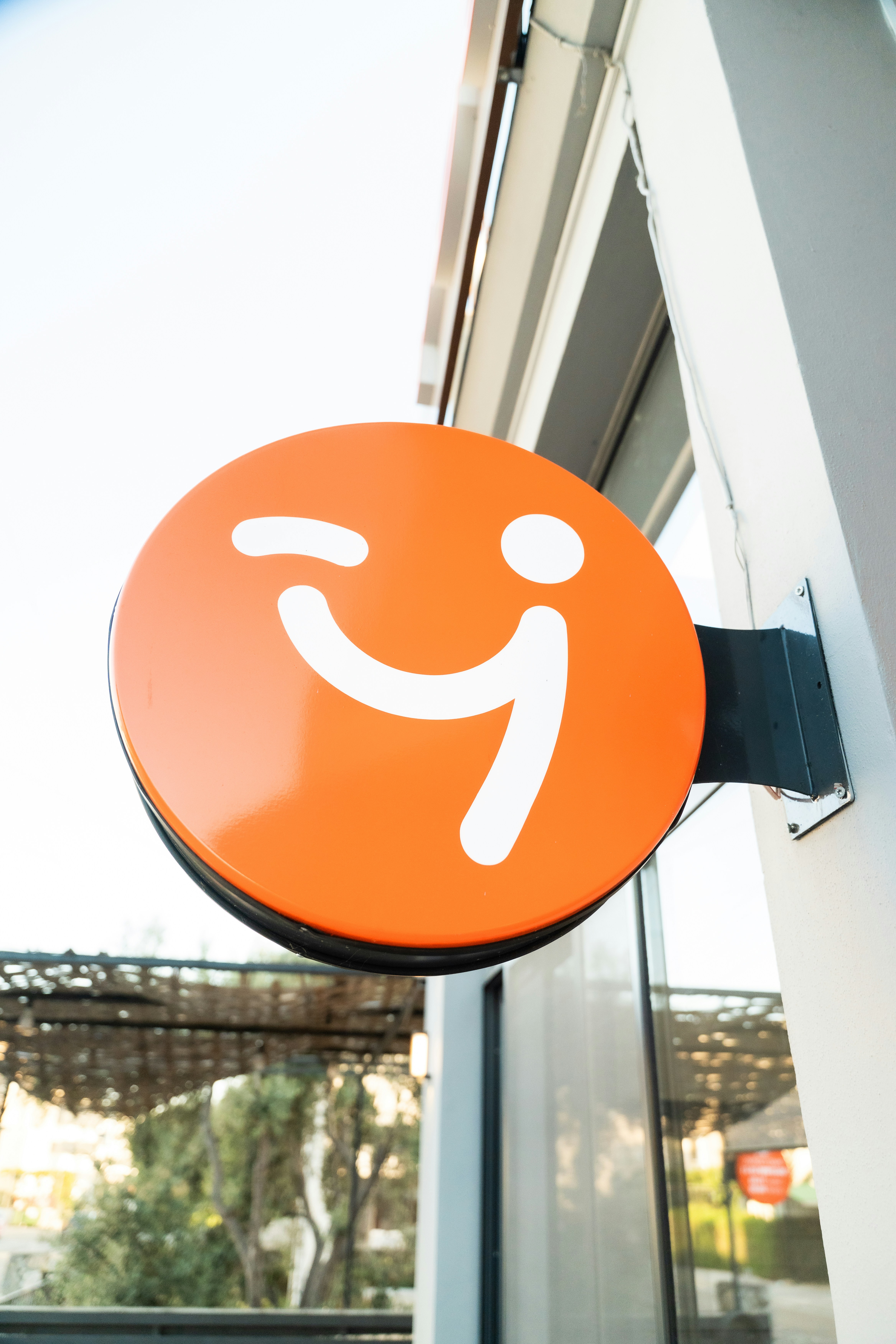 Orange Smiling Sign Boldly Anchors the Storefront