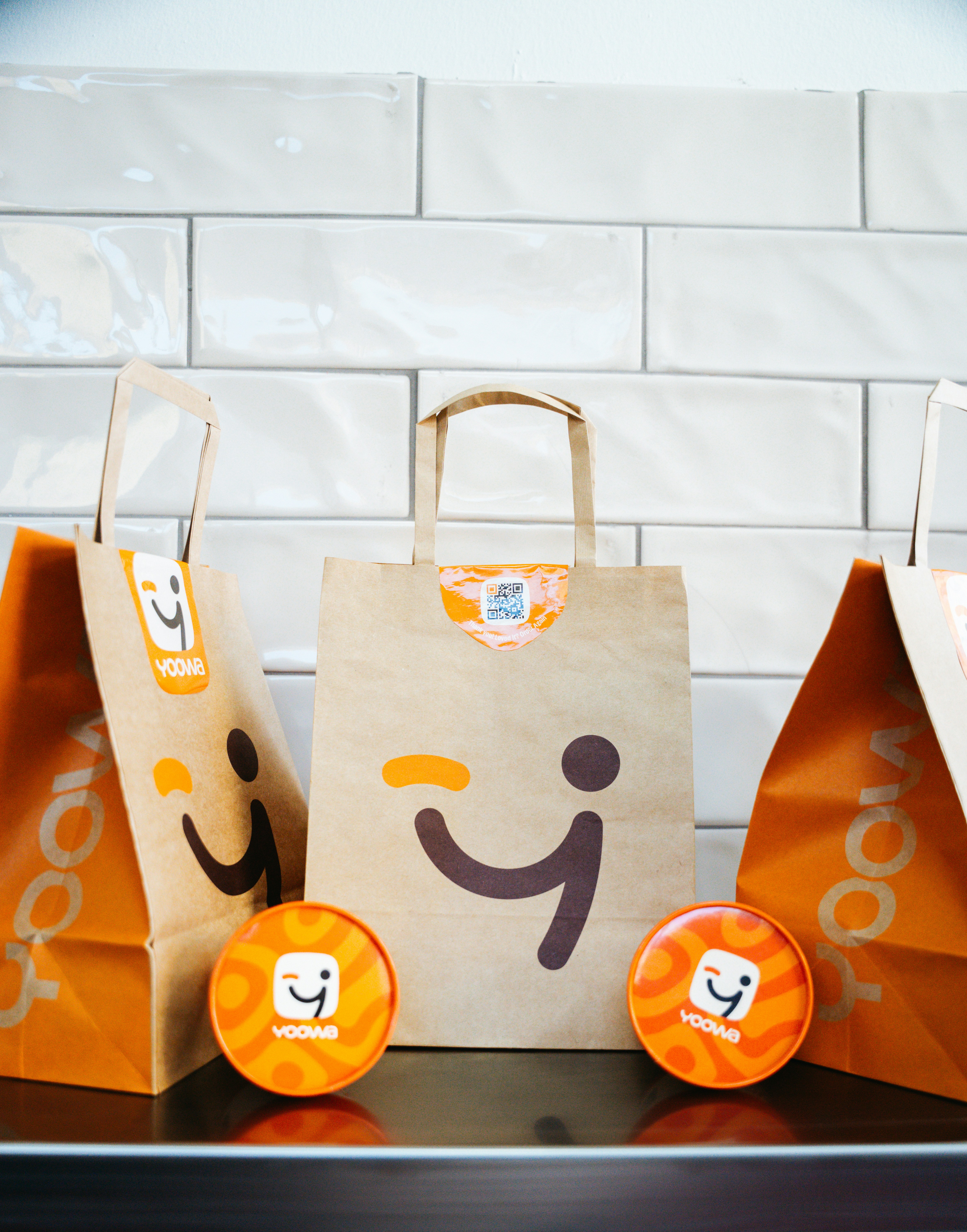 Smiling delivery: cheerful VOOM bags lining a clean tiled backdrop