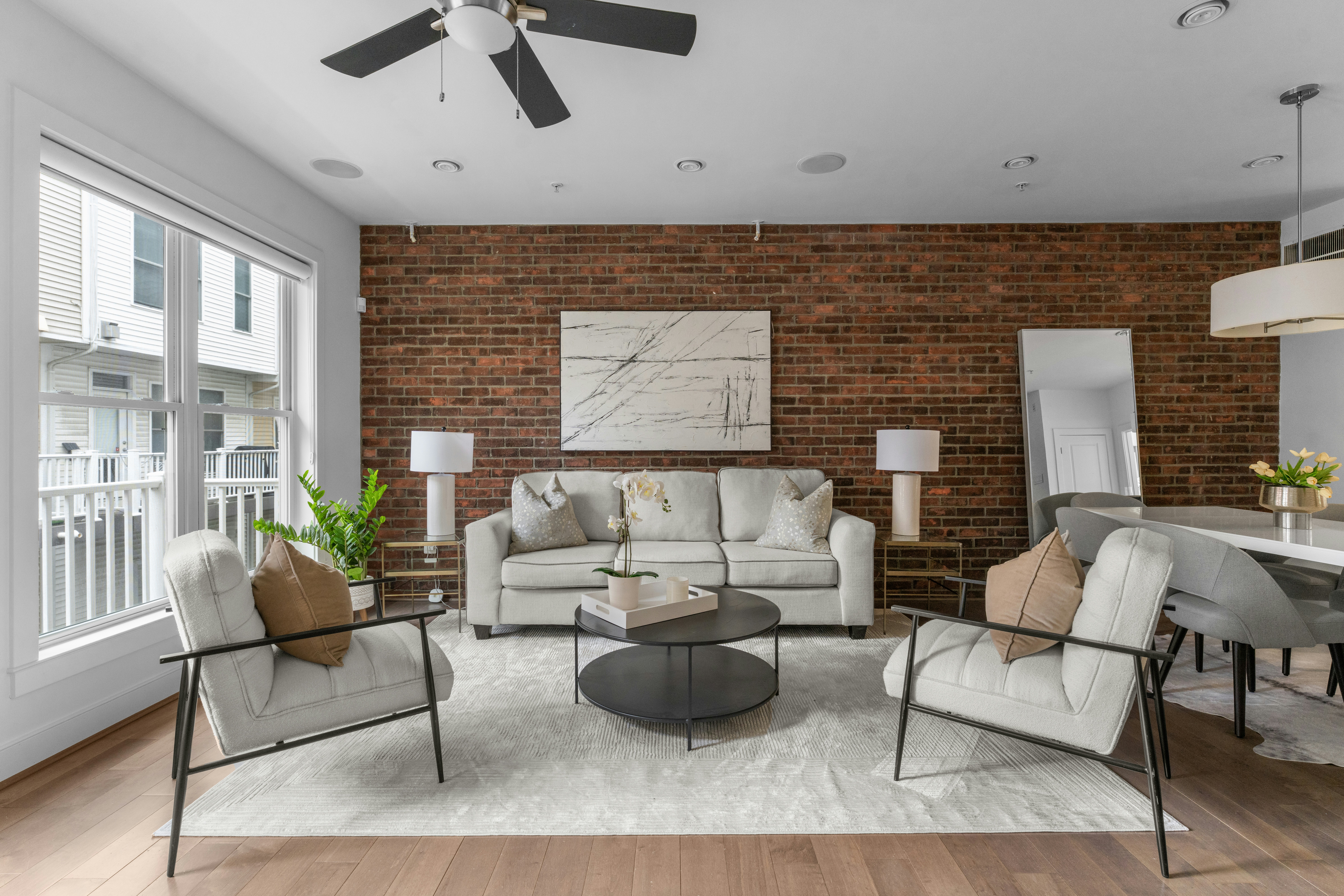 Brick-wall living room with white lounge and plants