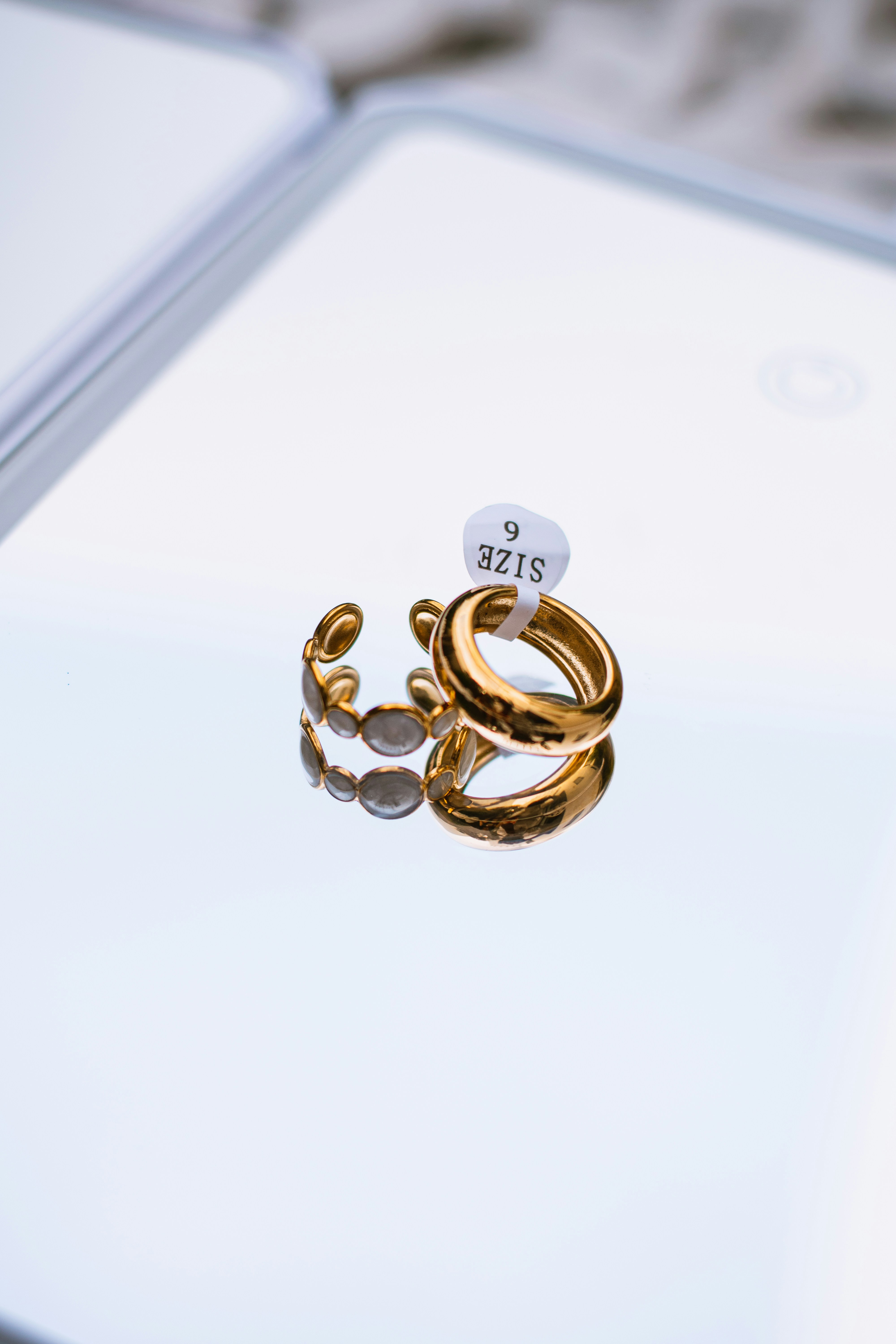 Golden rings on a mirrored surface: a quiet still life