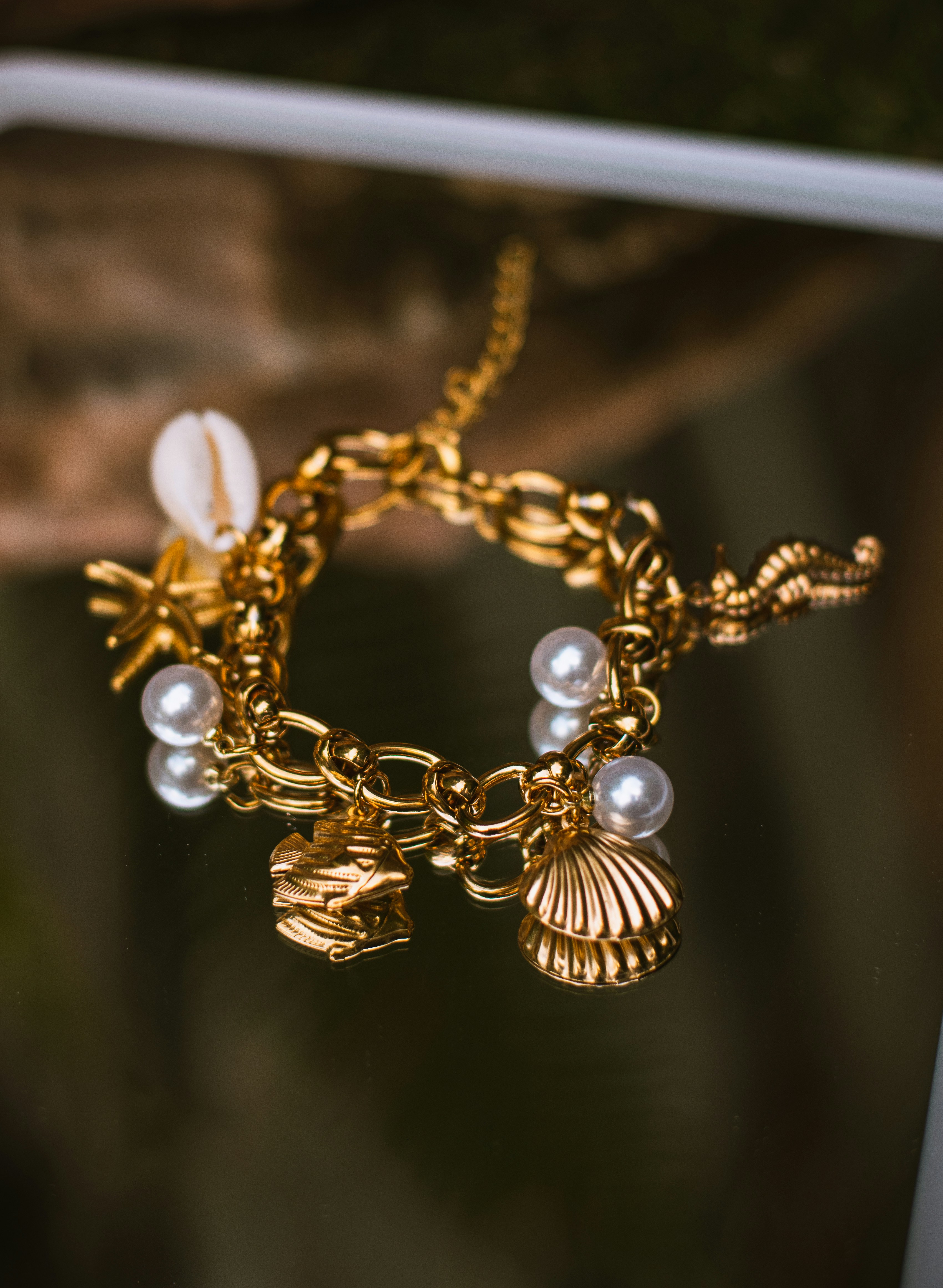 Golden Charms in Focus: Pearls, Shells, and Waves of Shine