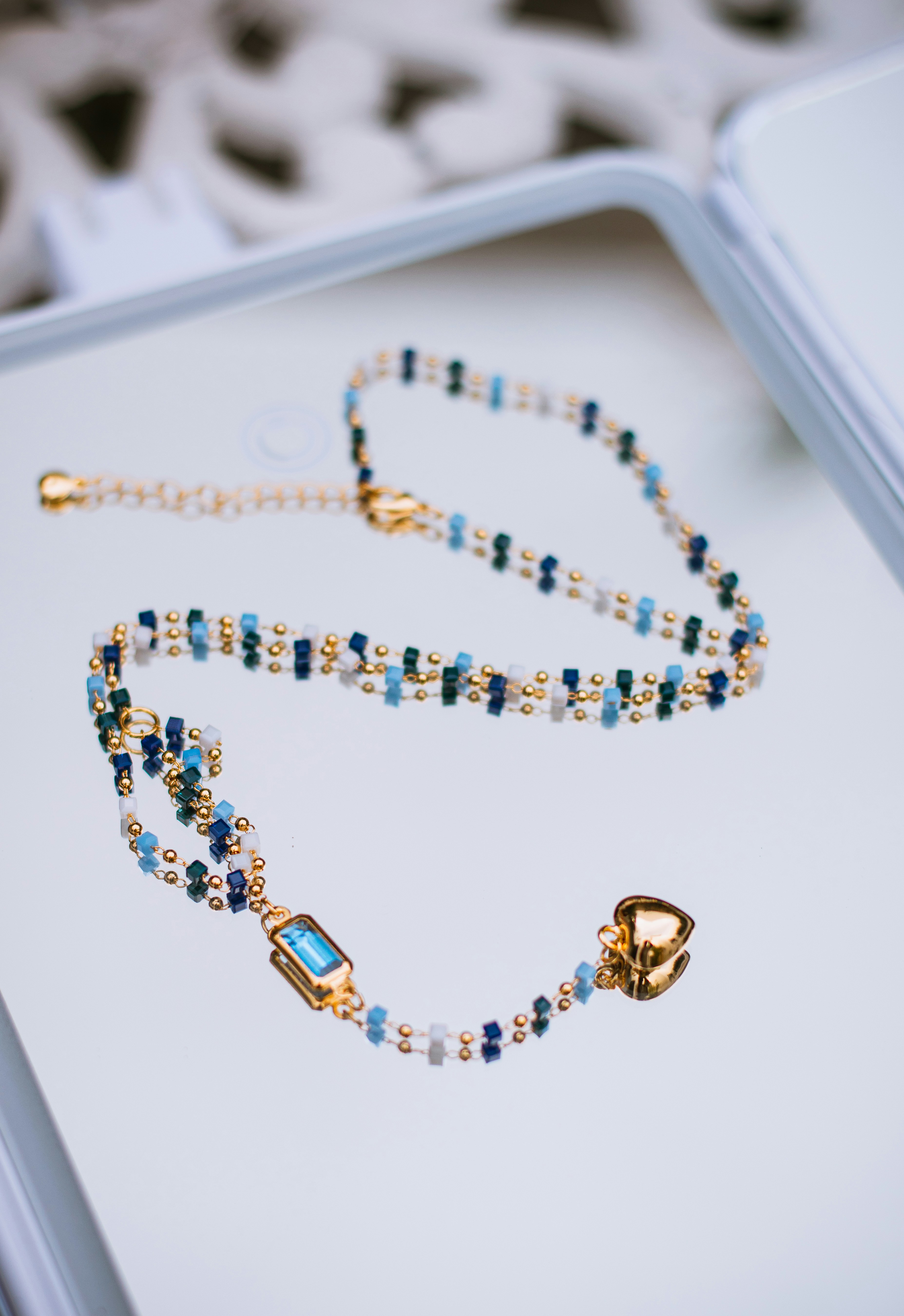 Azure and Gold: Beaded Jewelry Spreading Light Across a White Tray