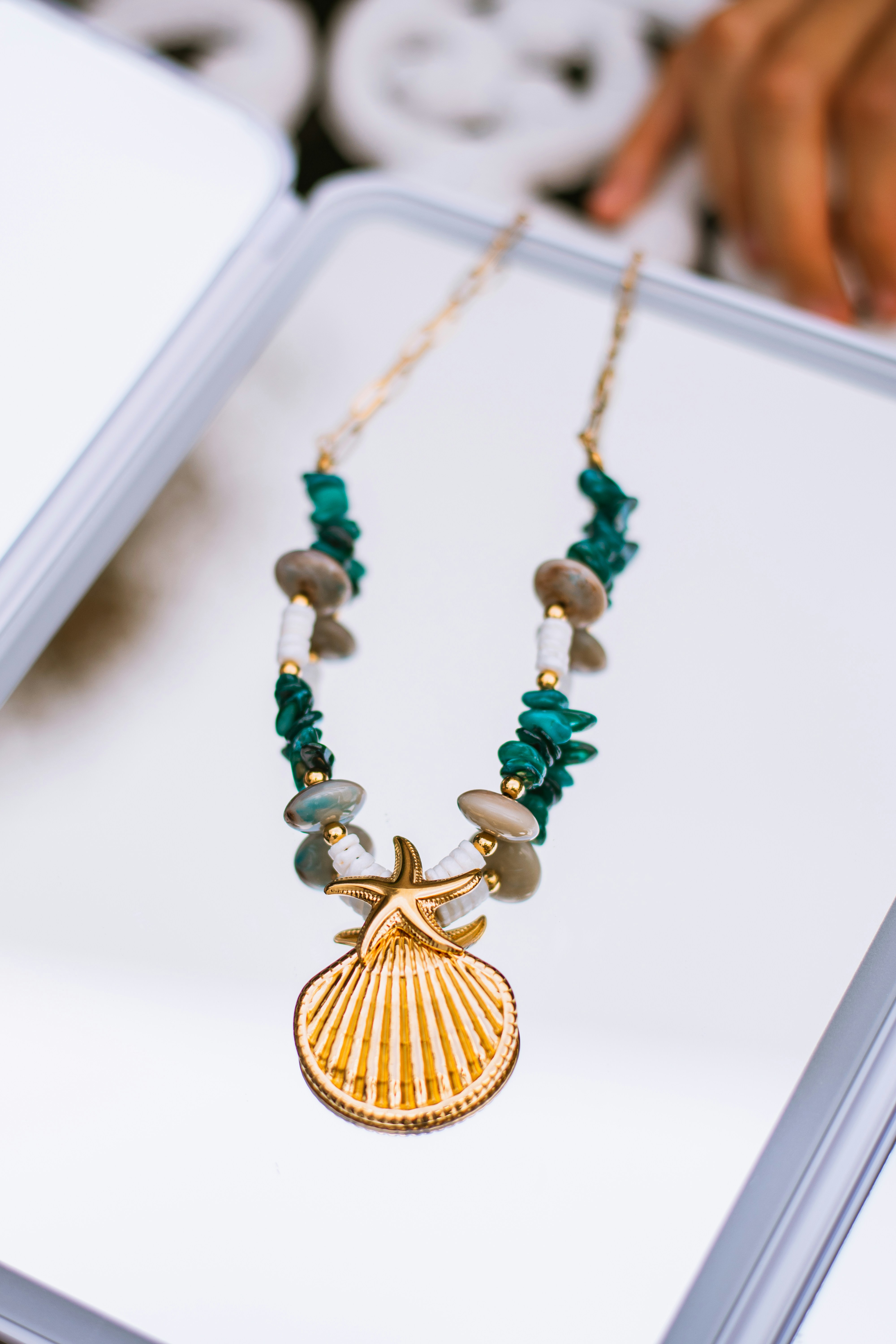 Gold Seashell Pendant Resting in a Jewelry Open Box