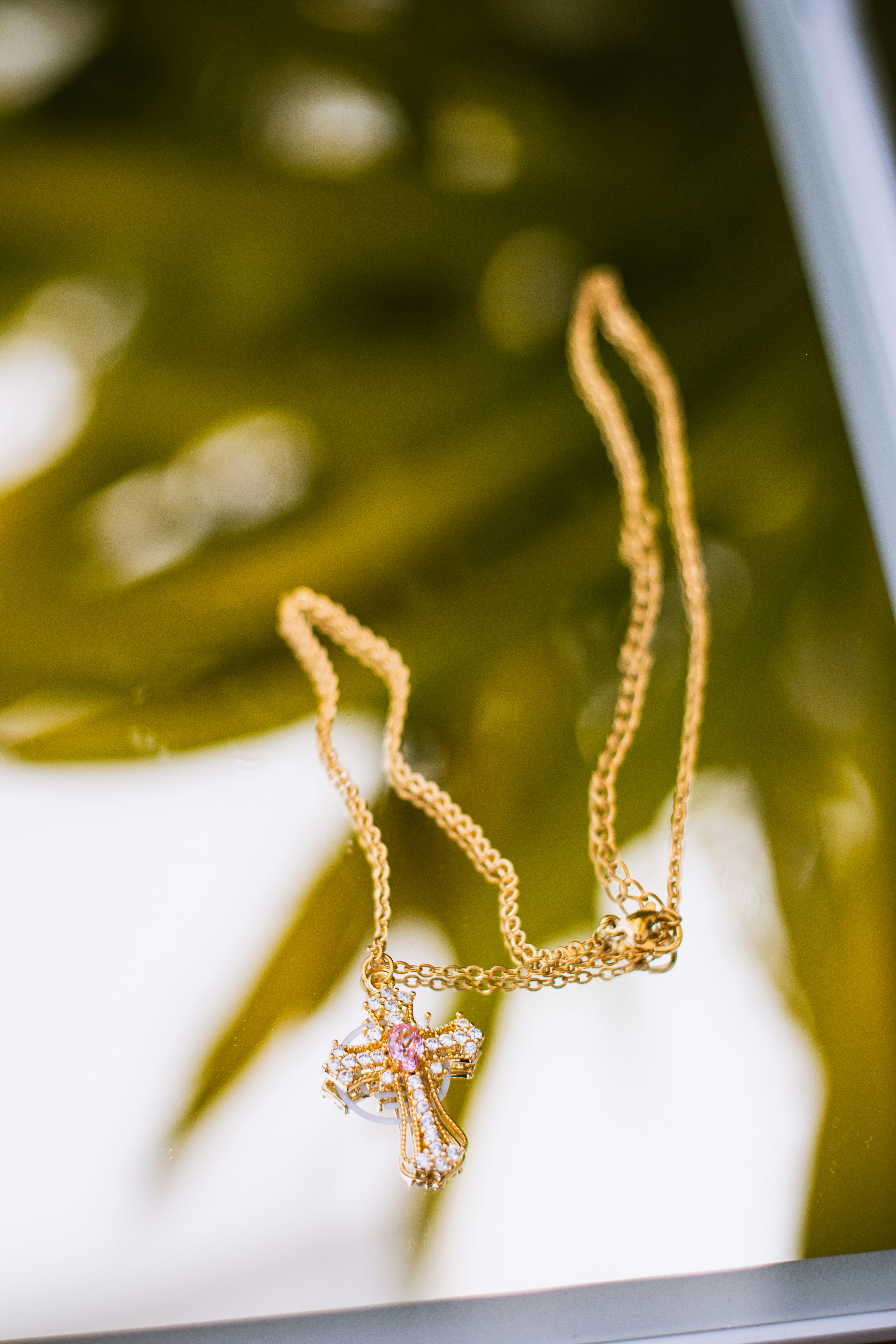 Gold Chain Necklace with Pendant Dangling Over Soft Focus Background