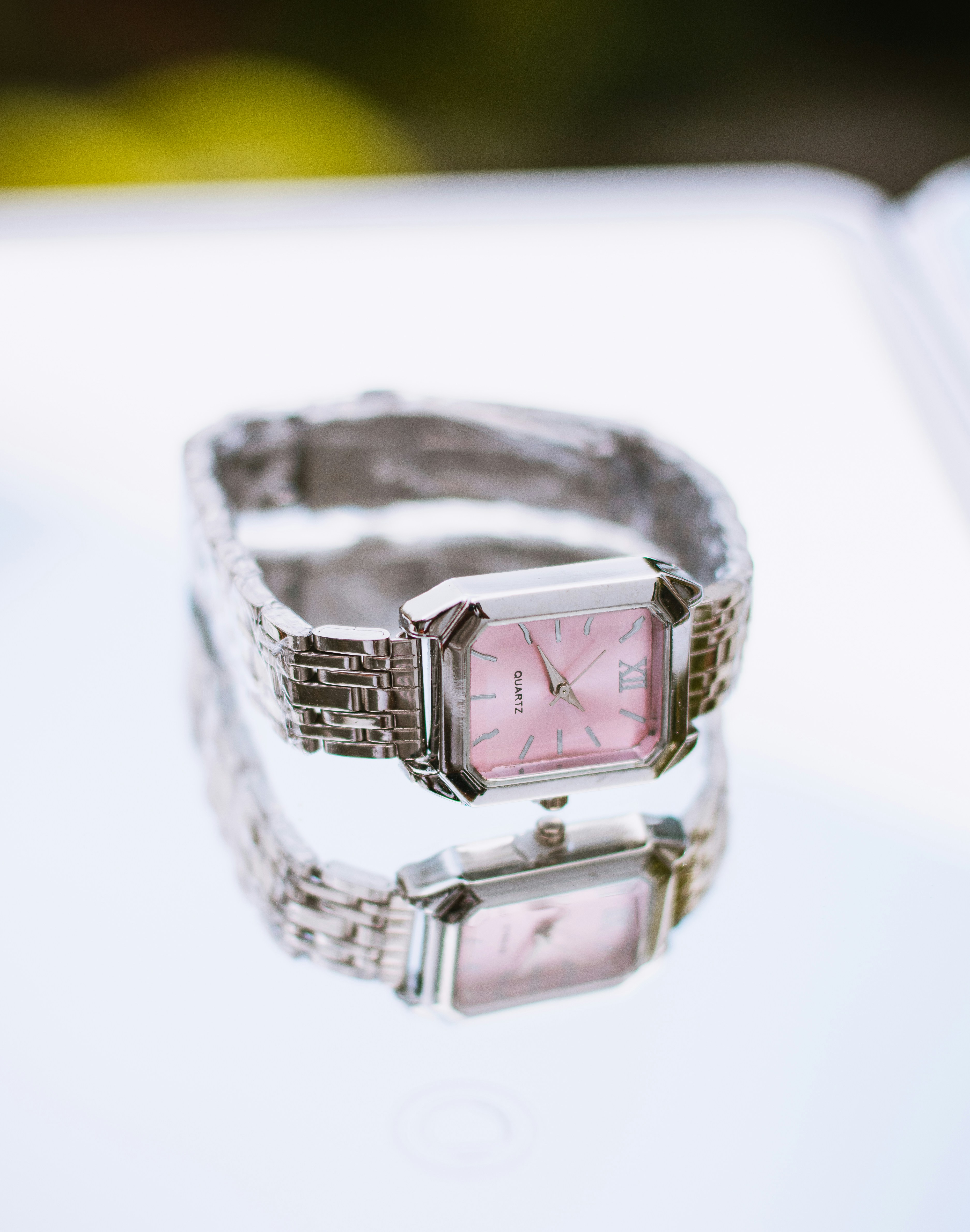 Pink Time: Reflections of a Silver Bracelet on Glass