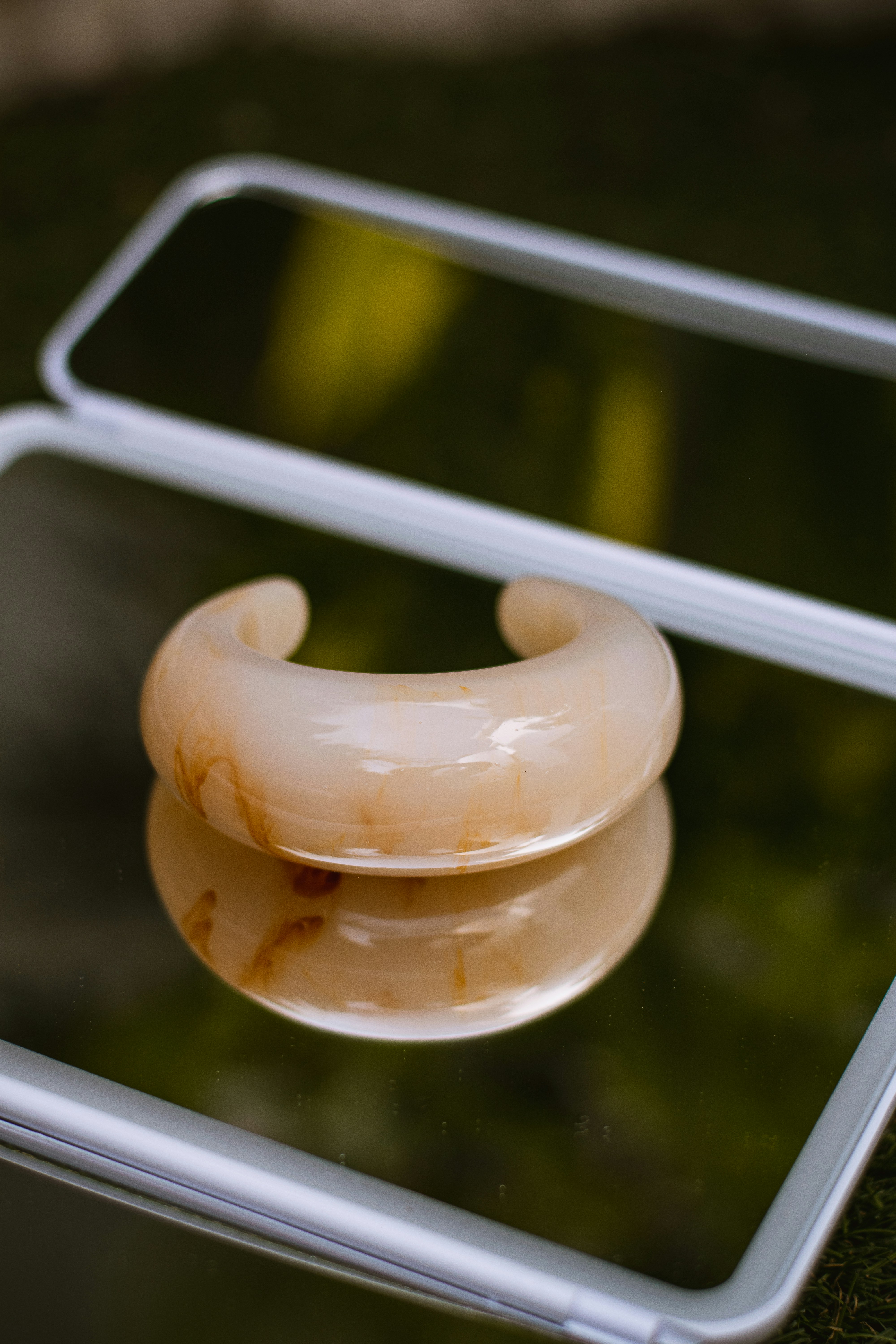 Reflective Ceramic Hoop Resting on Glass Surface