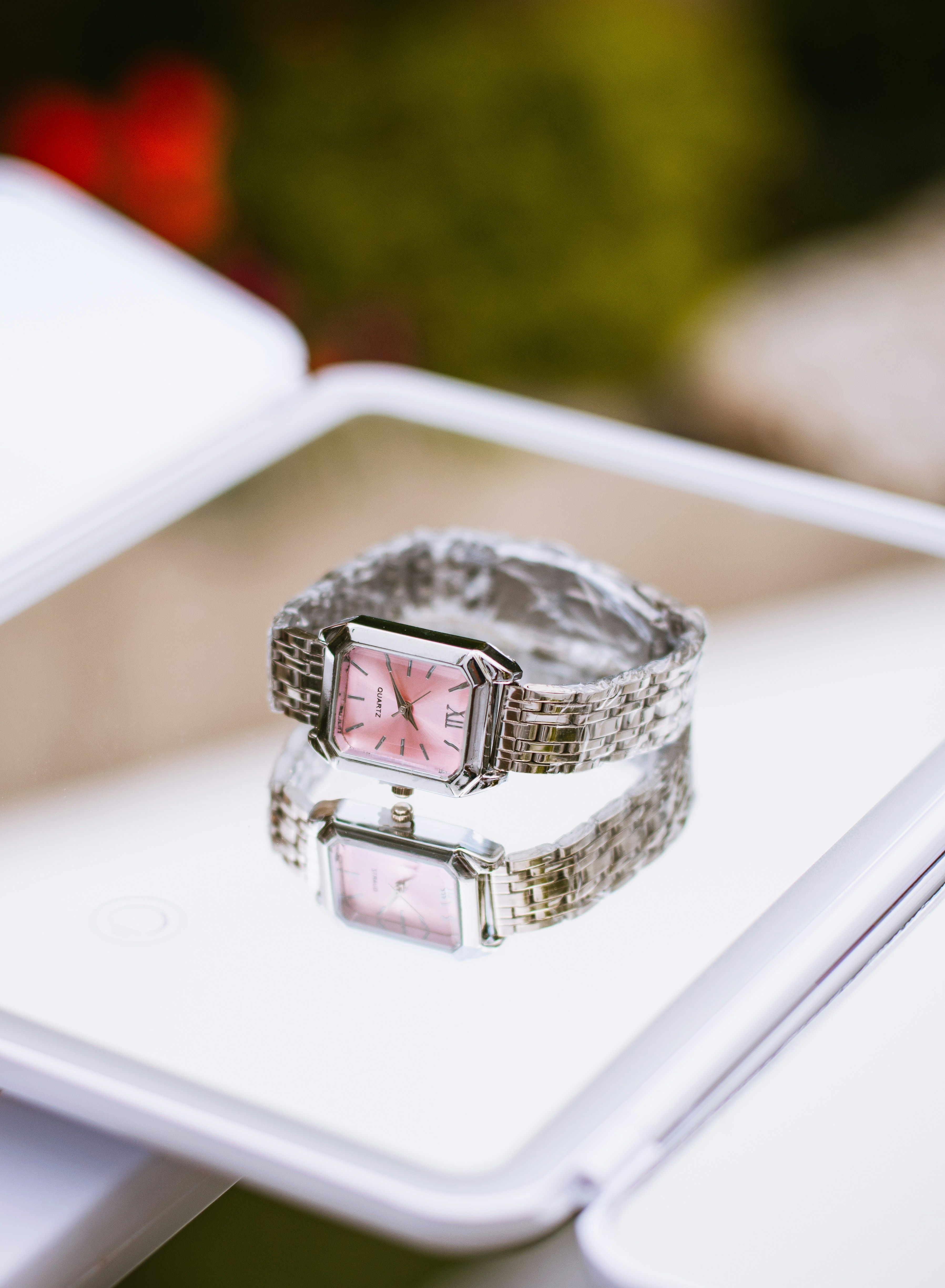 Pink Timepiece: A Reflective Moment on a Silver Wristwatch
