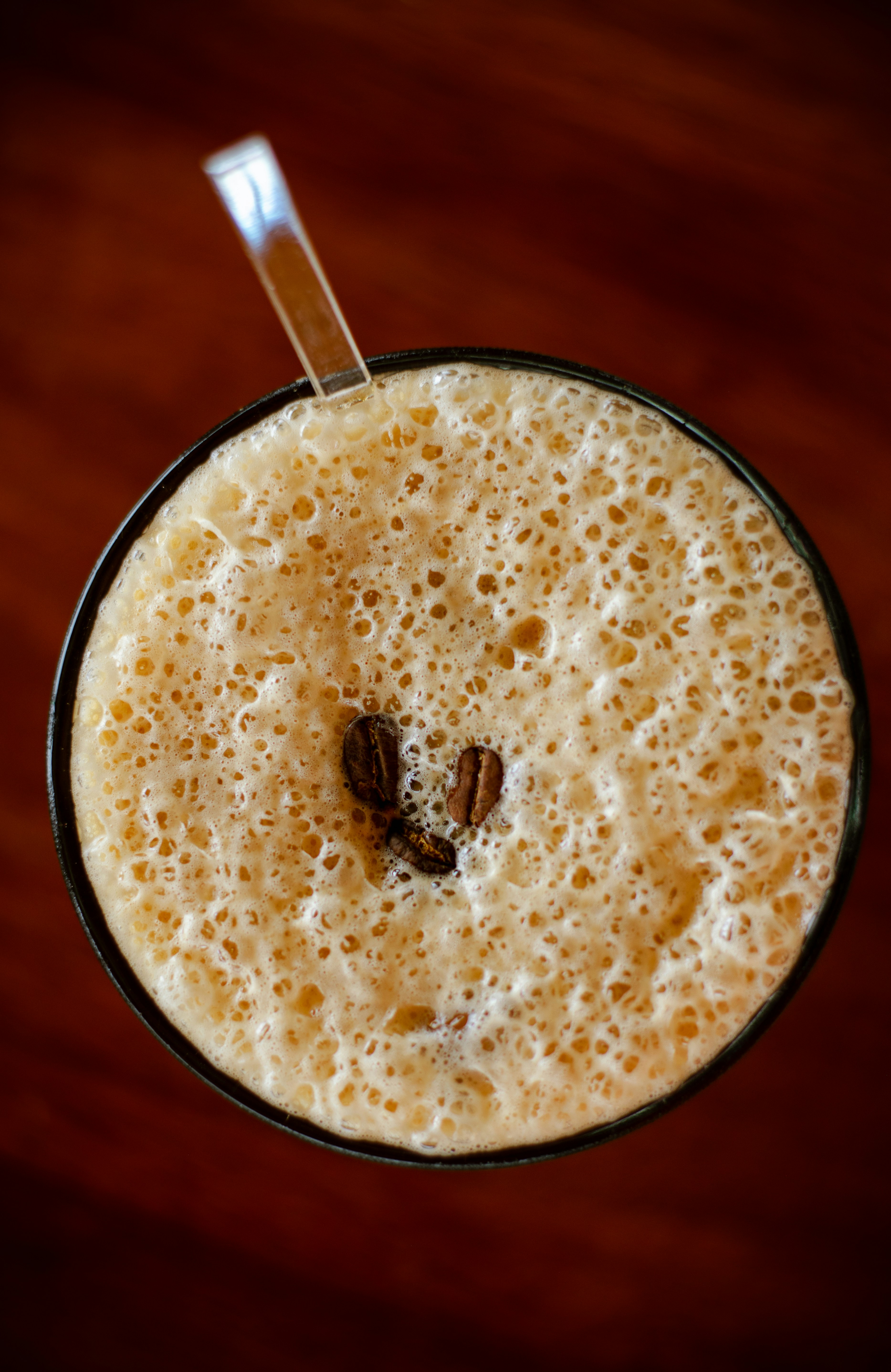 Foamy Fragrance: A Top-Down Cup with Coffee Beans at Rest