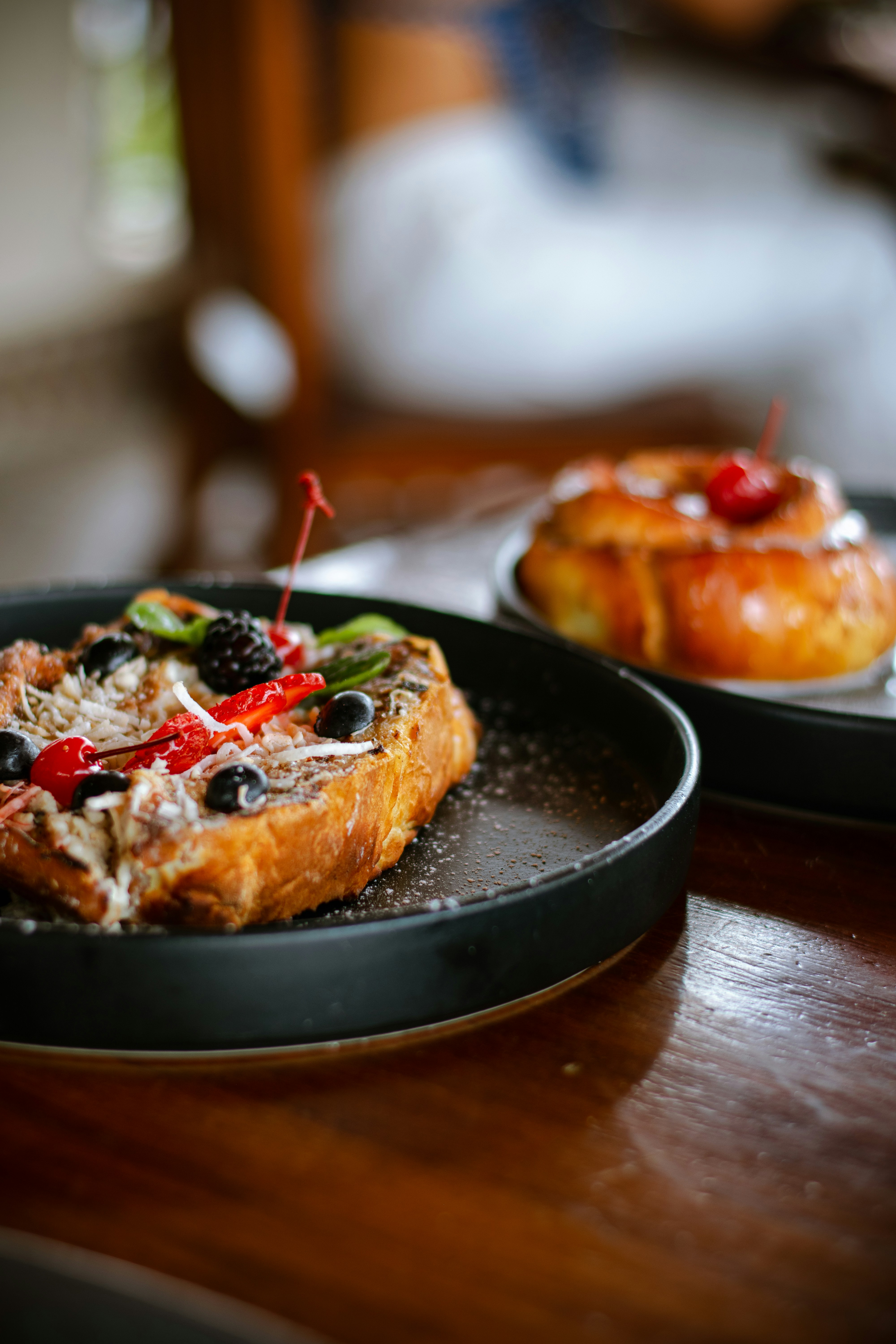 Citrus-scented Sweetness: A Pair of Gourmet Pastries on a Rustic Table