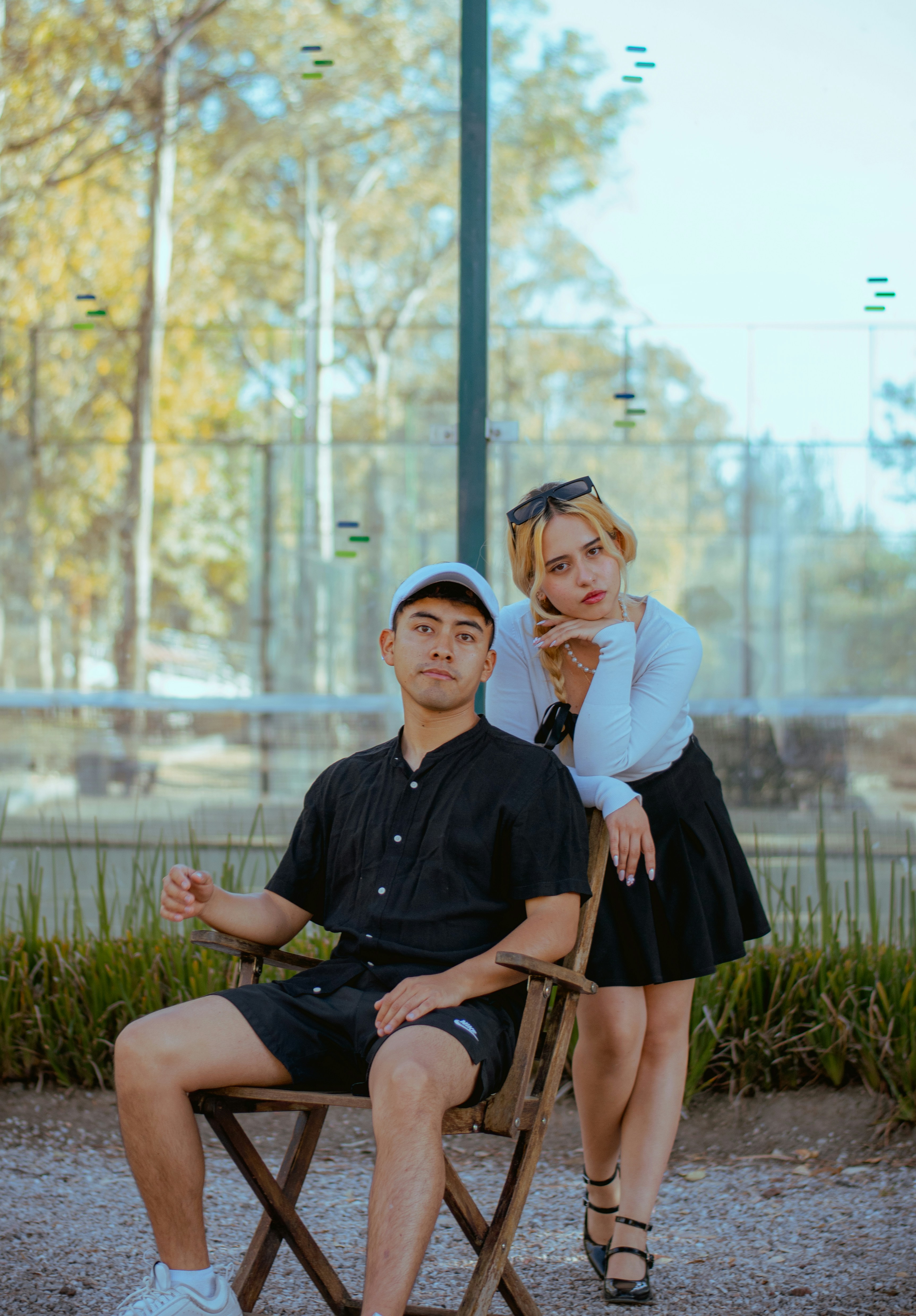 Two Friends in a Quiet Park: A Casual Portrait by the Fence