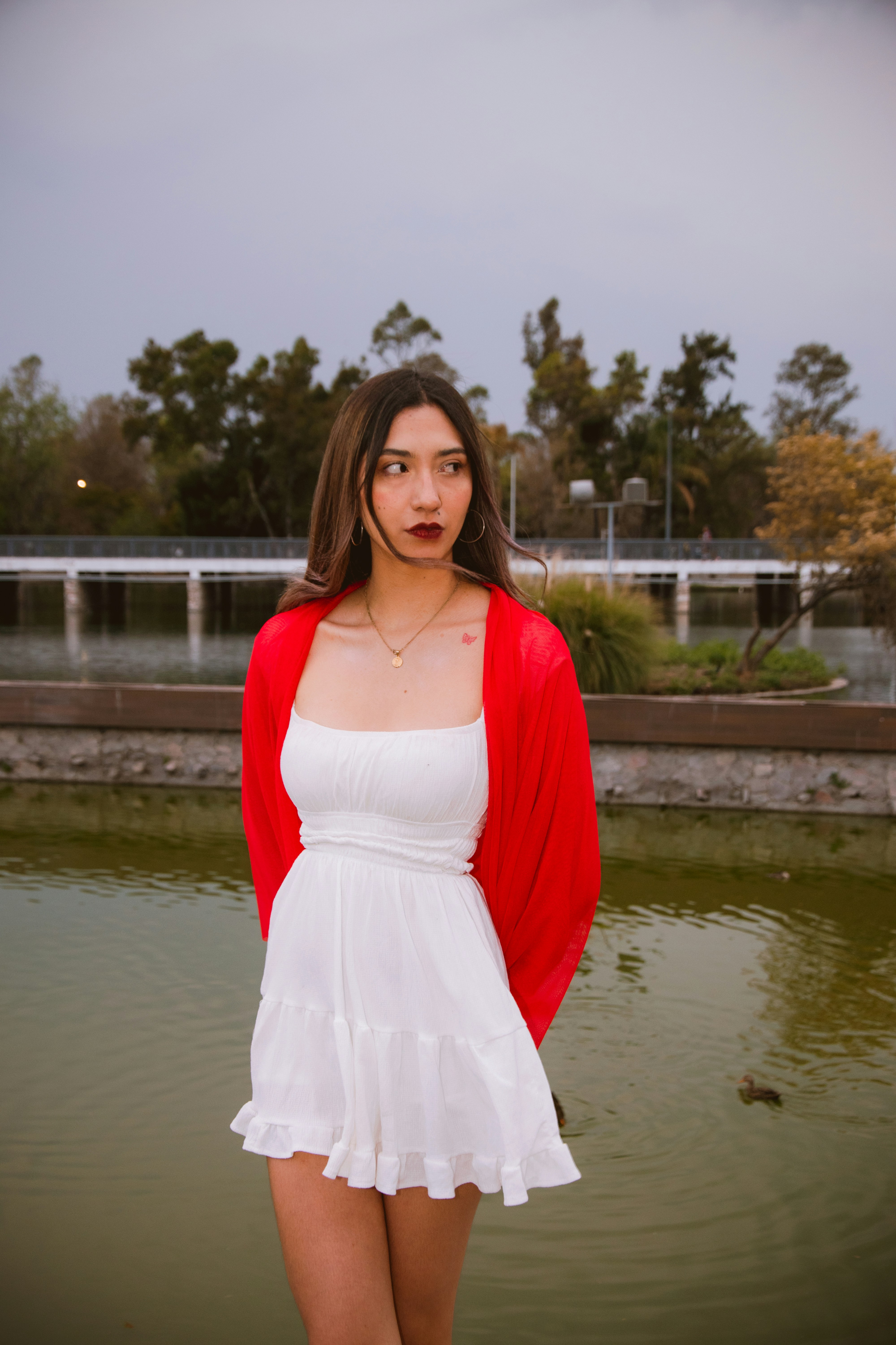 Red Cardigan, White Dress, by the Water's Edge