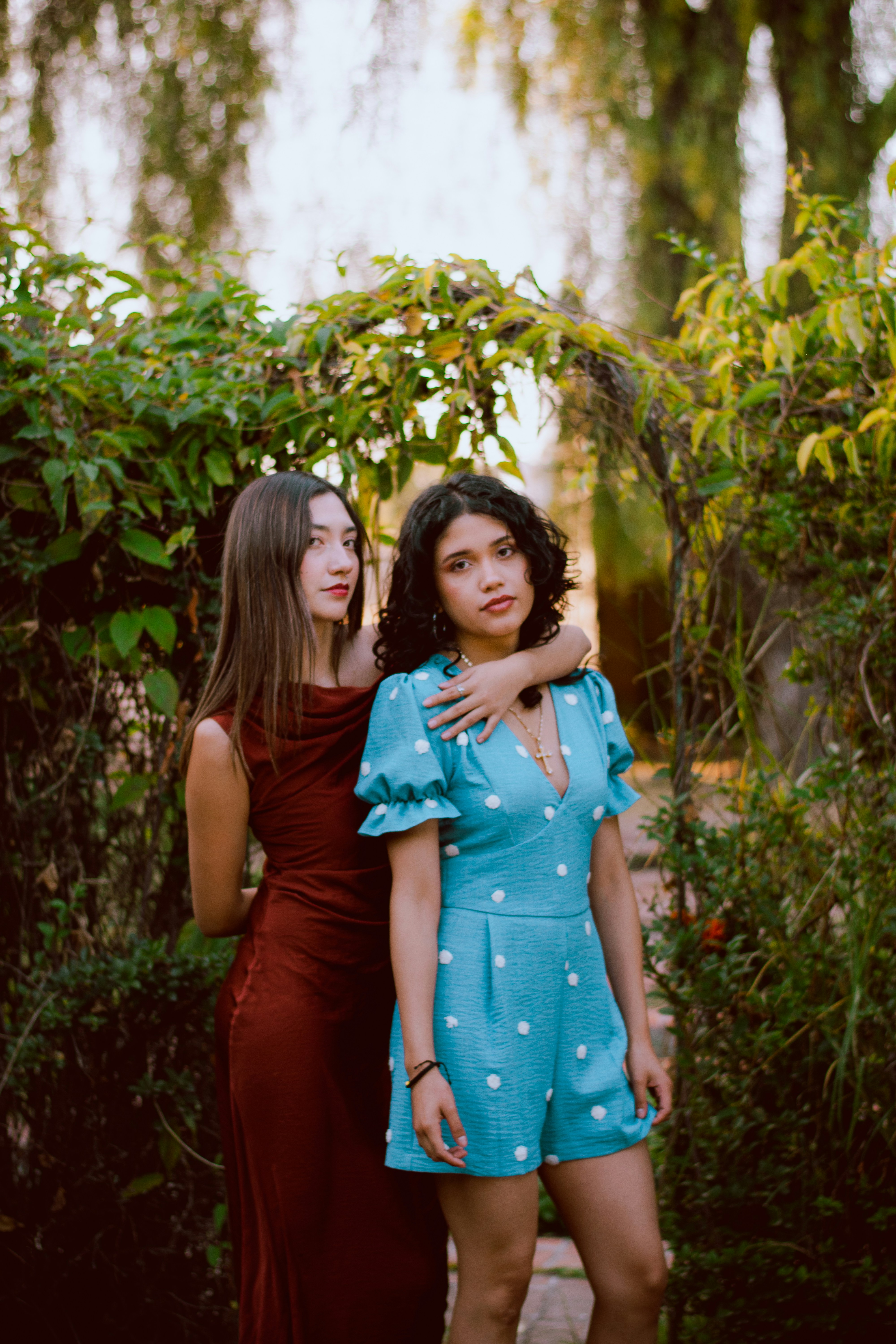 Two Friends in a Verdant Song: A Moment Between Dresses and Leaves