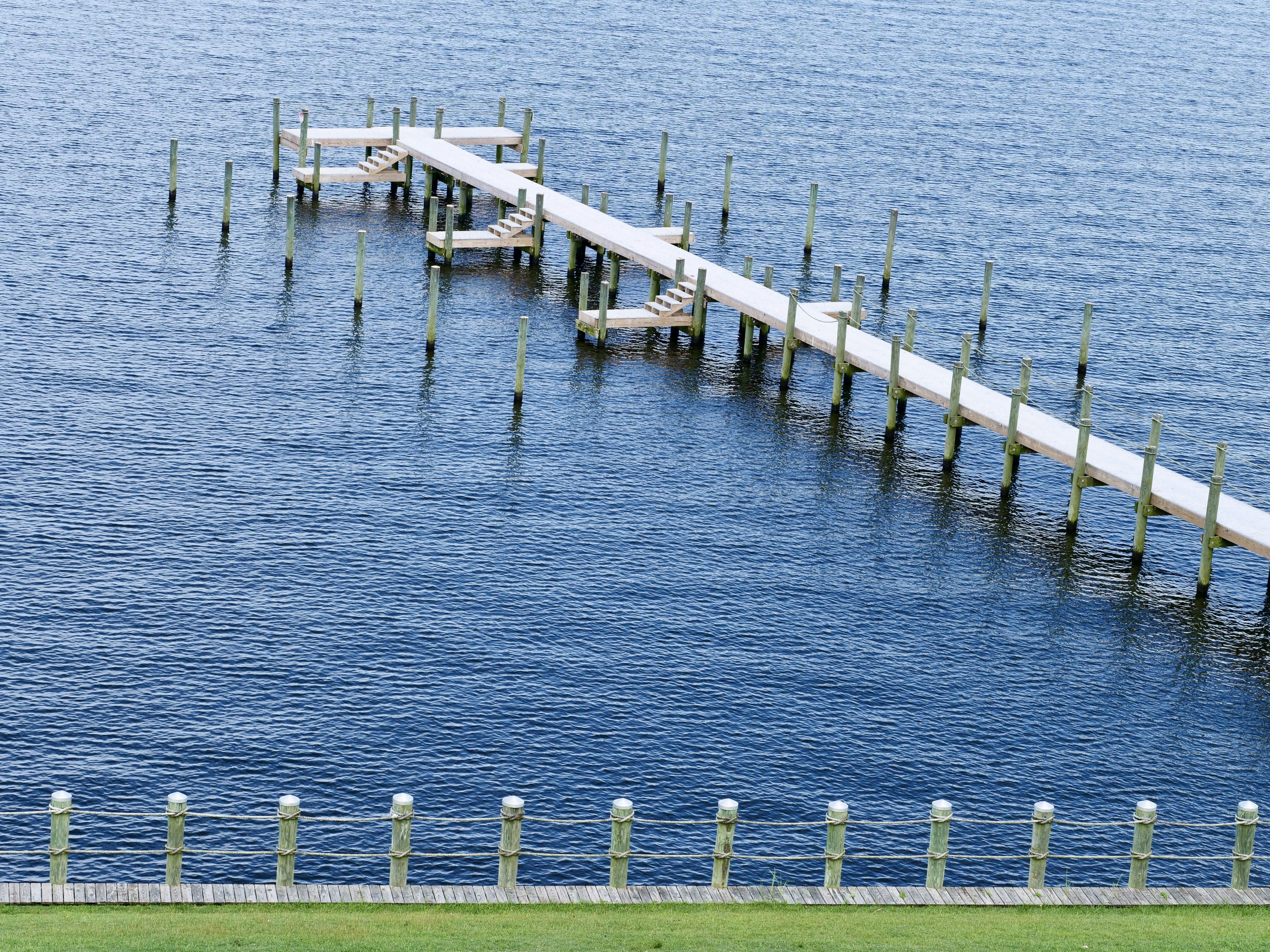 Long Pier Reaching into a Calm Blue Mirror