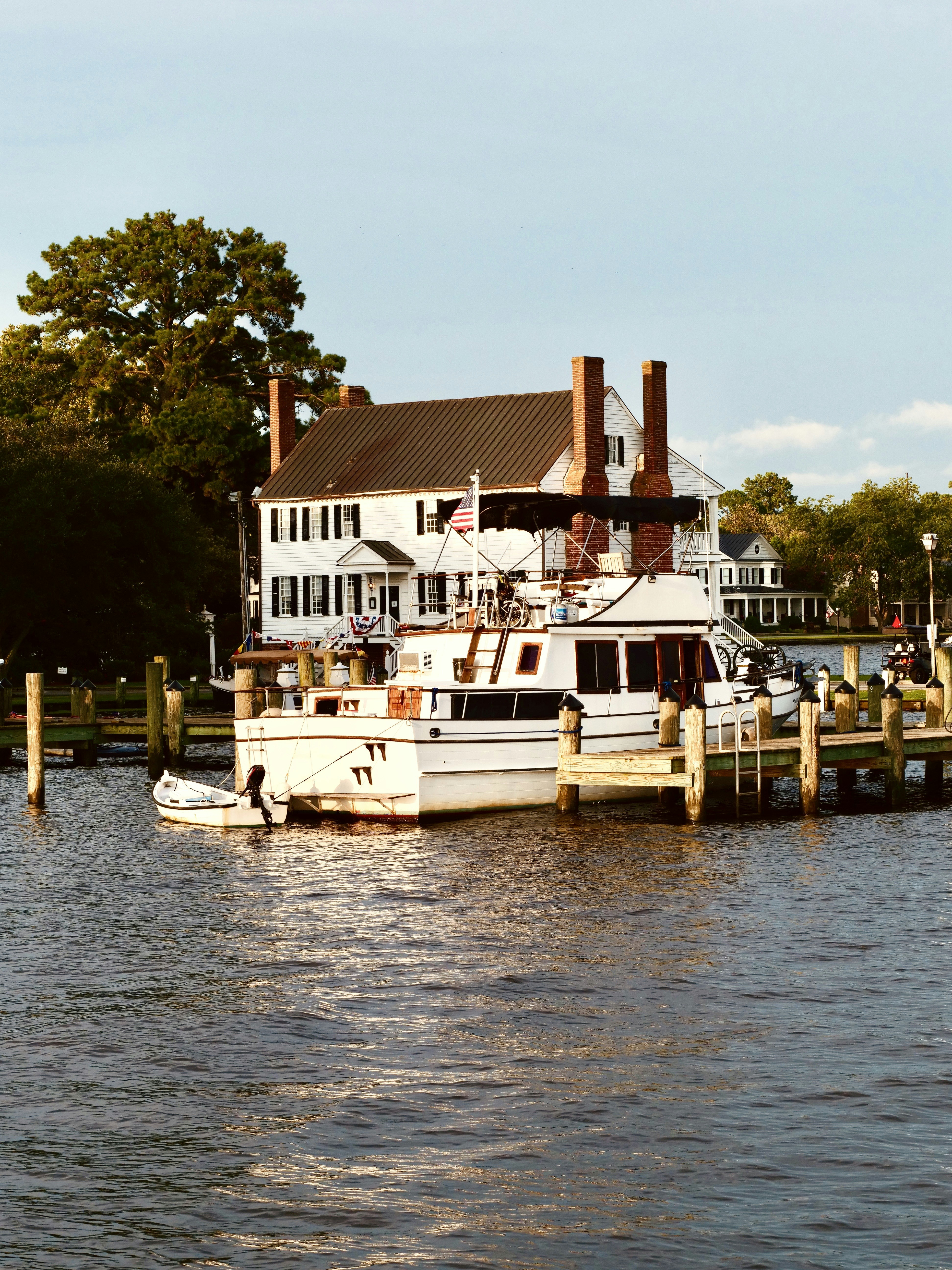 Harbor Residence: A White Boat Resting Near a Historic House by the Docks