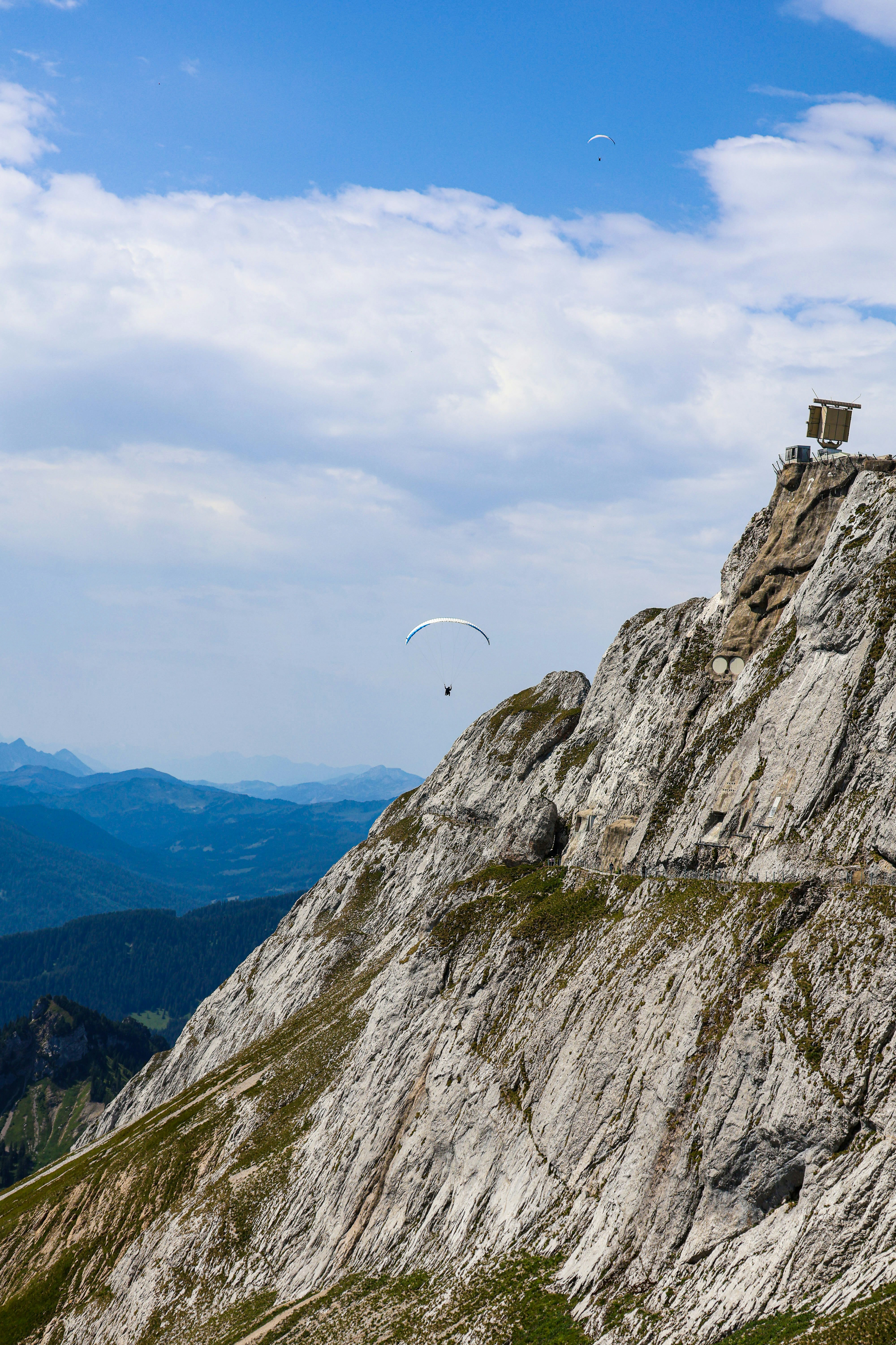 Paragliding Grace Above a Rugged Alpine Climb