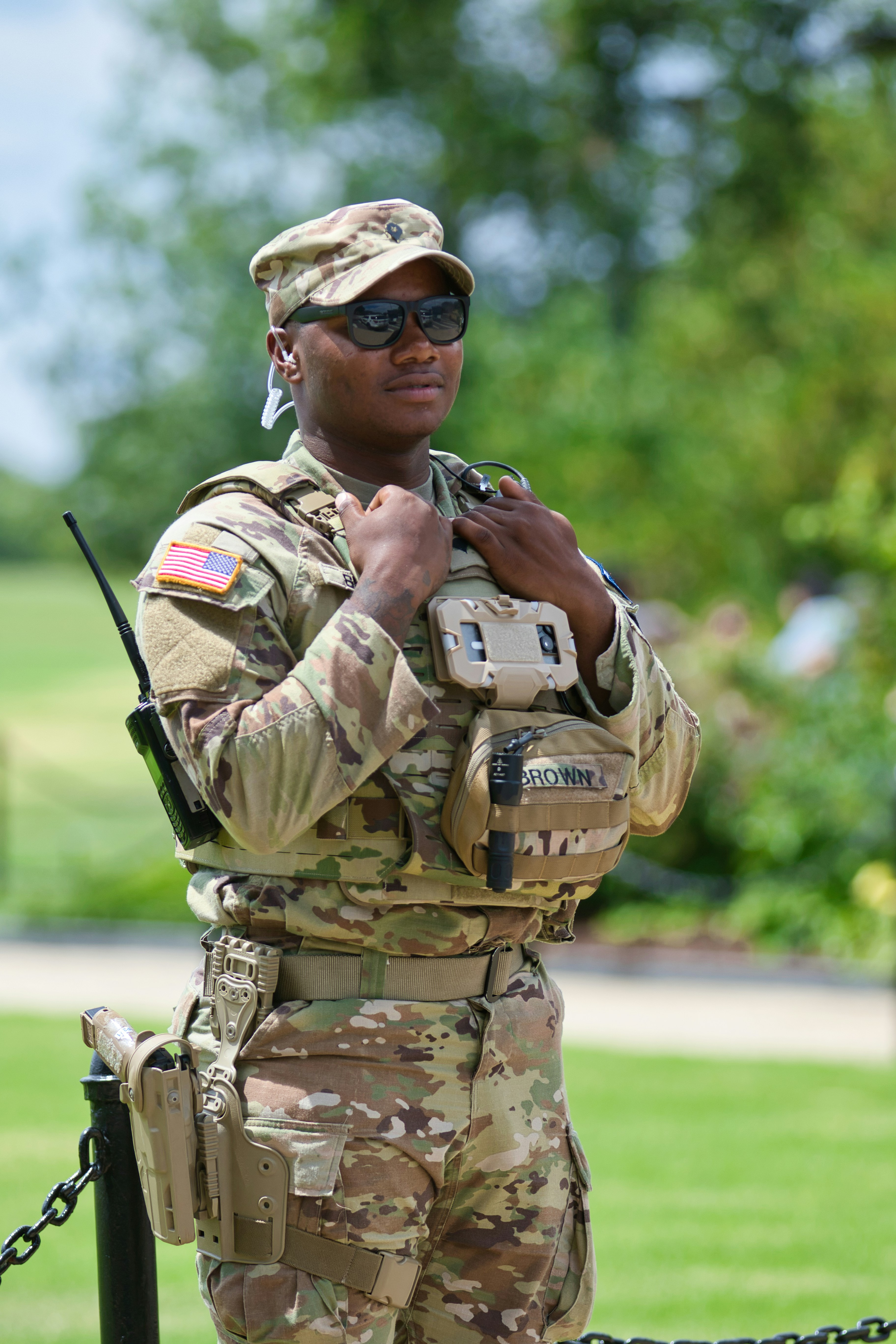 Quiet Confidence: Soldier Adjusting Gear in Park-Side Training