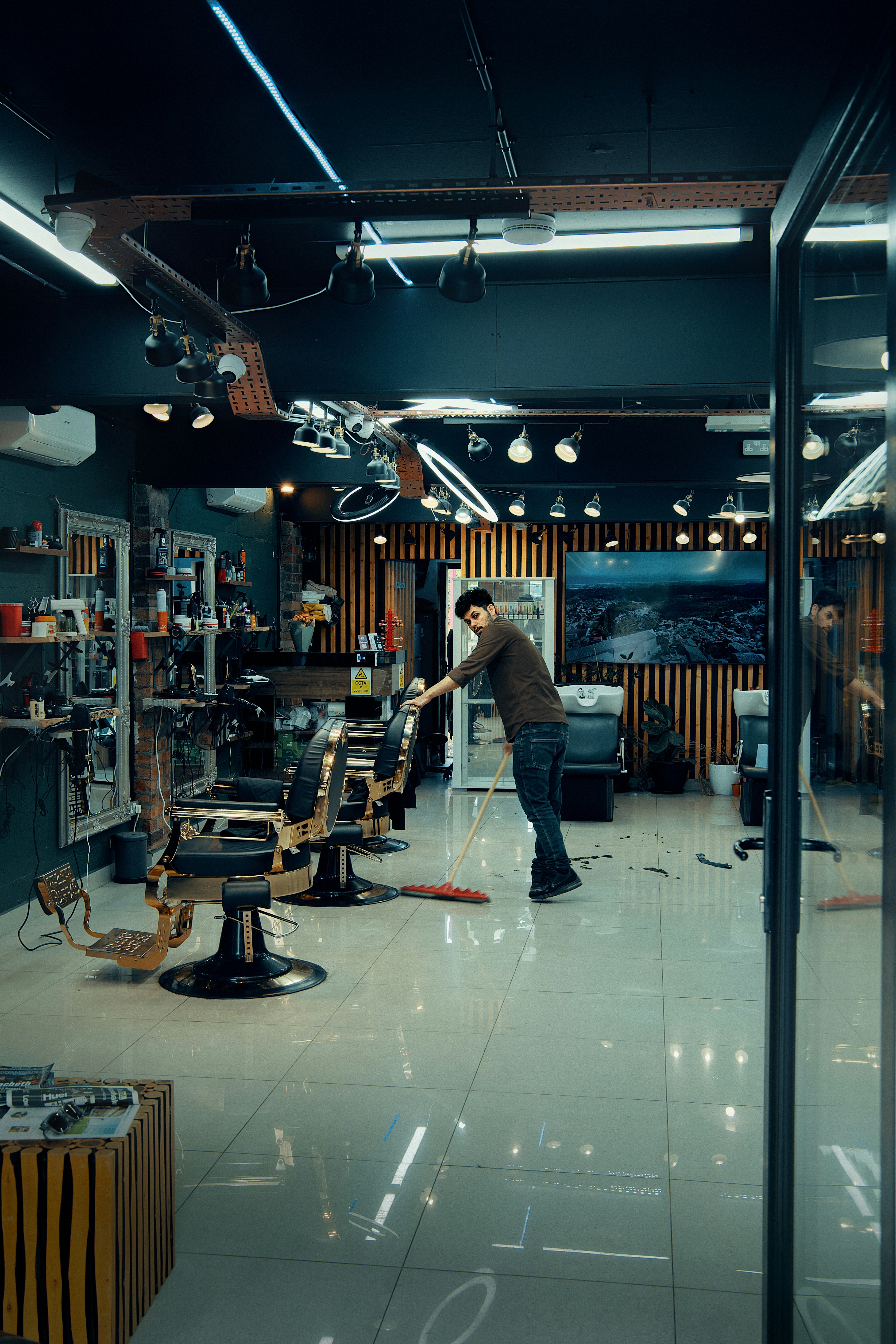 A Quiet Shift: A Barbershop Cleaned by a Solemn Sweep