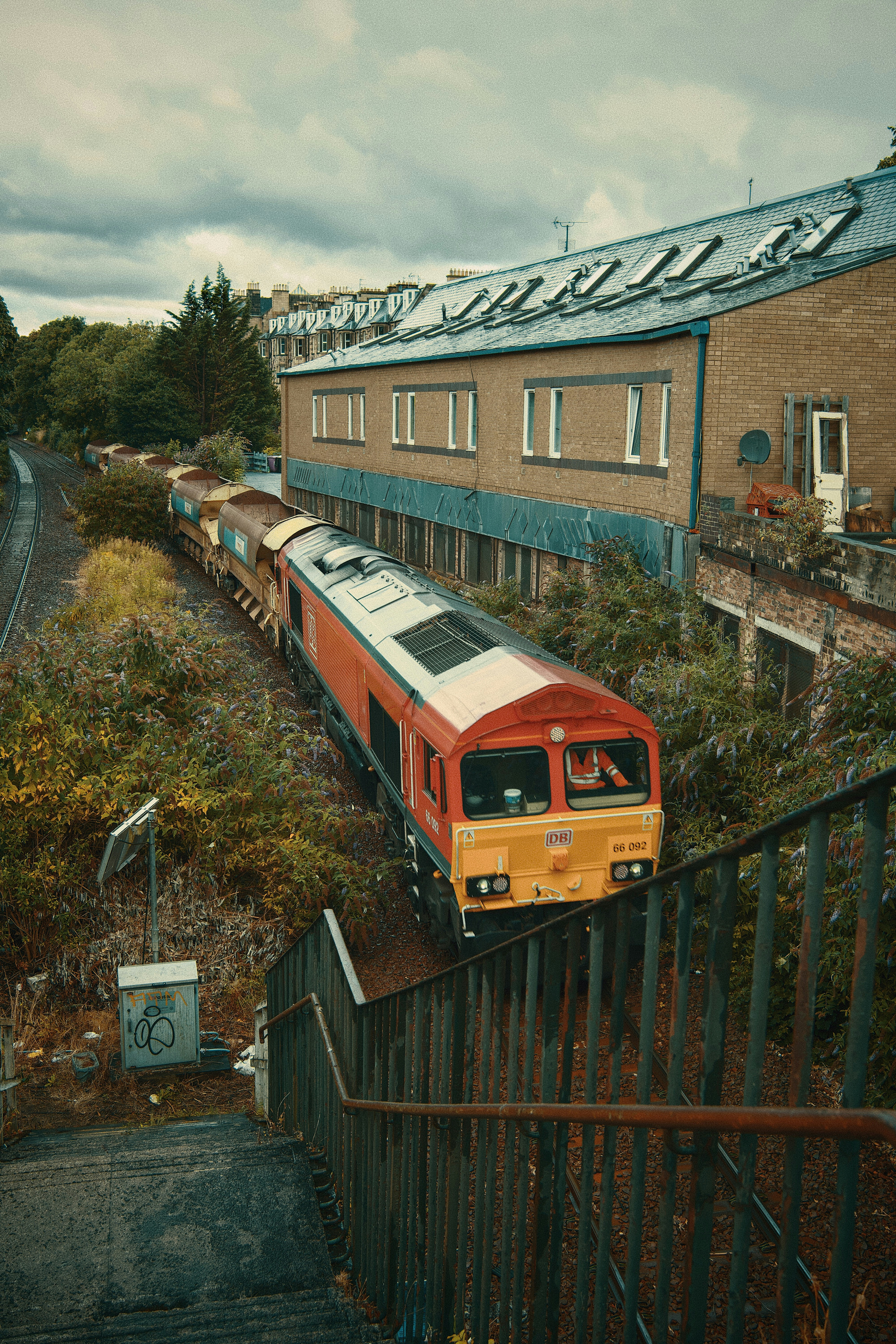 Red Intercity Rounding a Curve Along a Brick Station