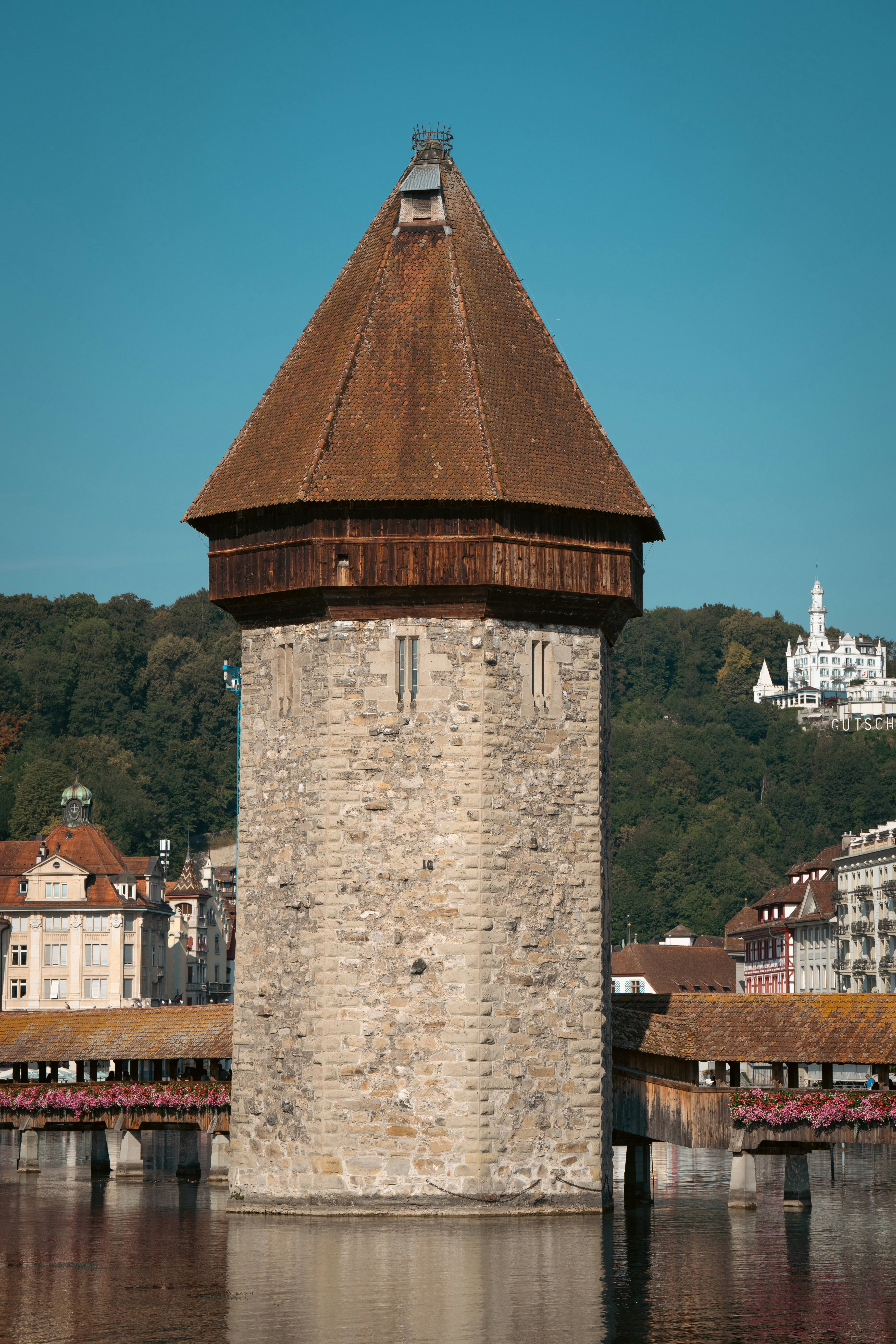 Stone Tower Rising from the Lake: a medieval landmark against a clear blue sky