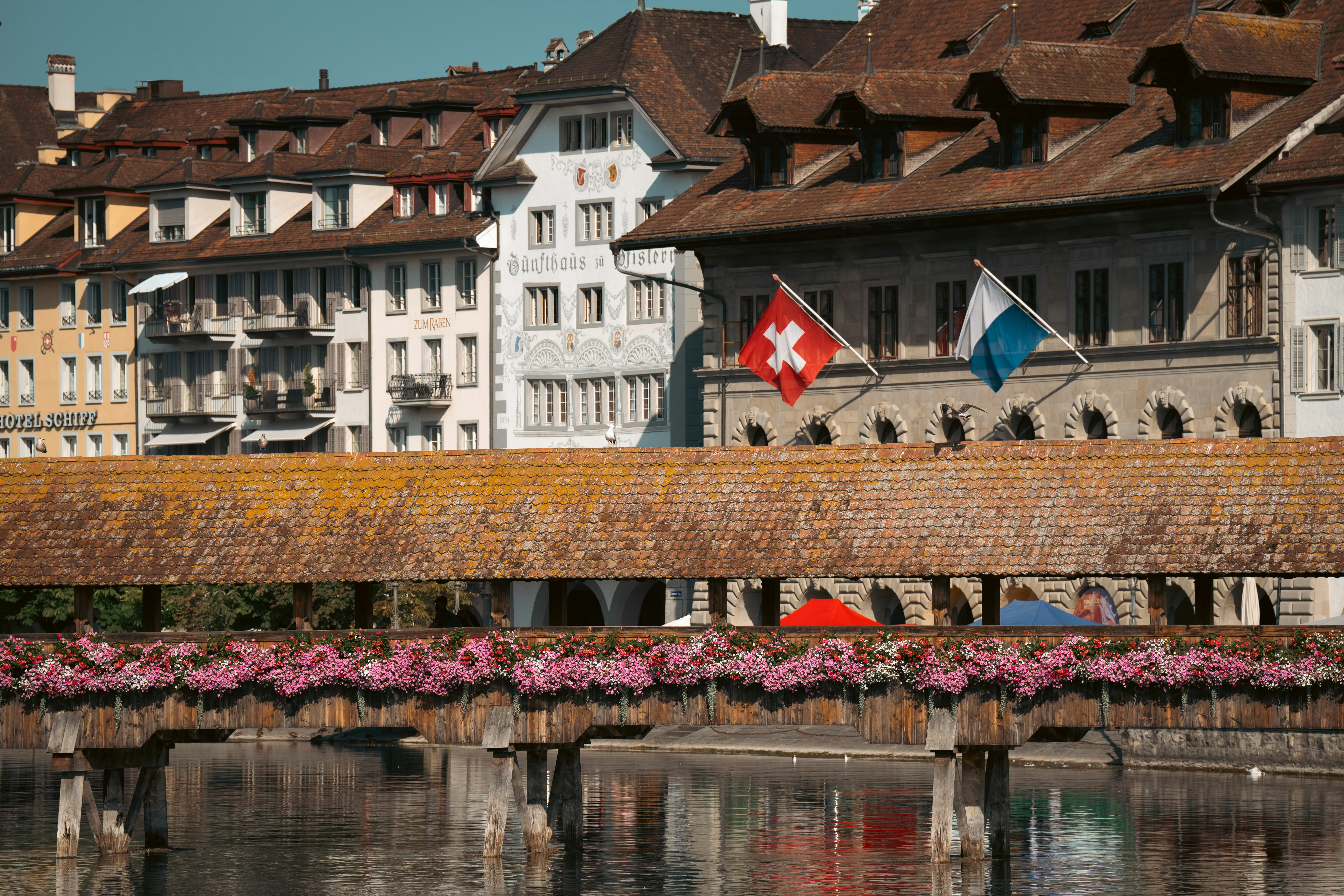 Swiss Flags Over a Riverside Bridge in a Swiss Town