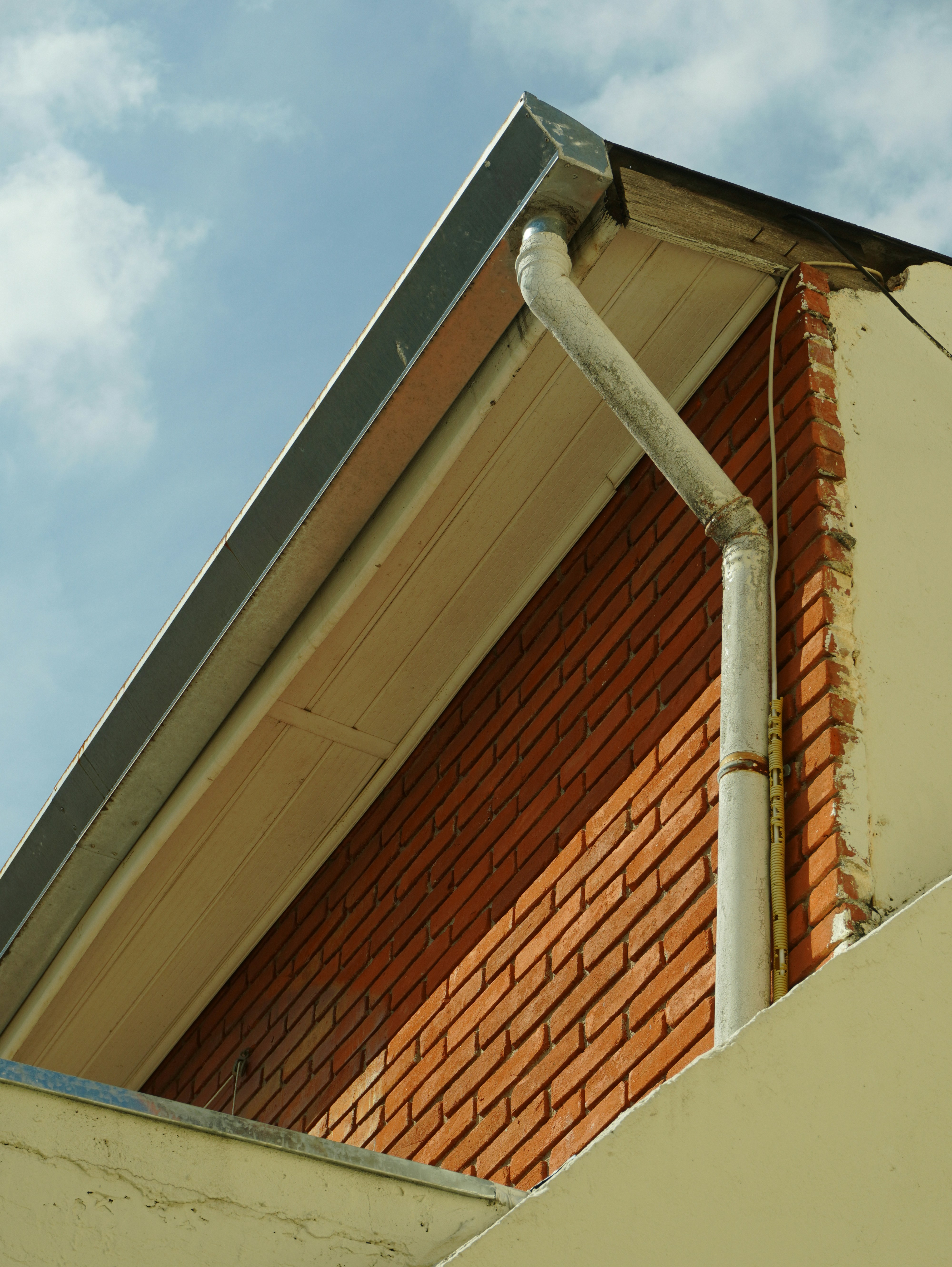 Brickwork and rain gutter against blue sky anatomy