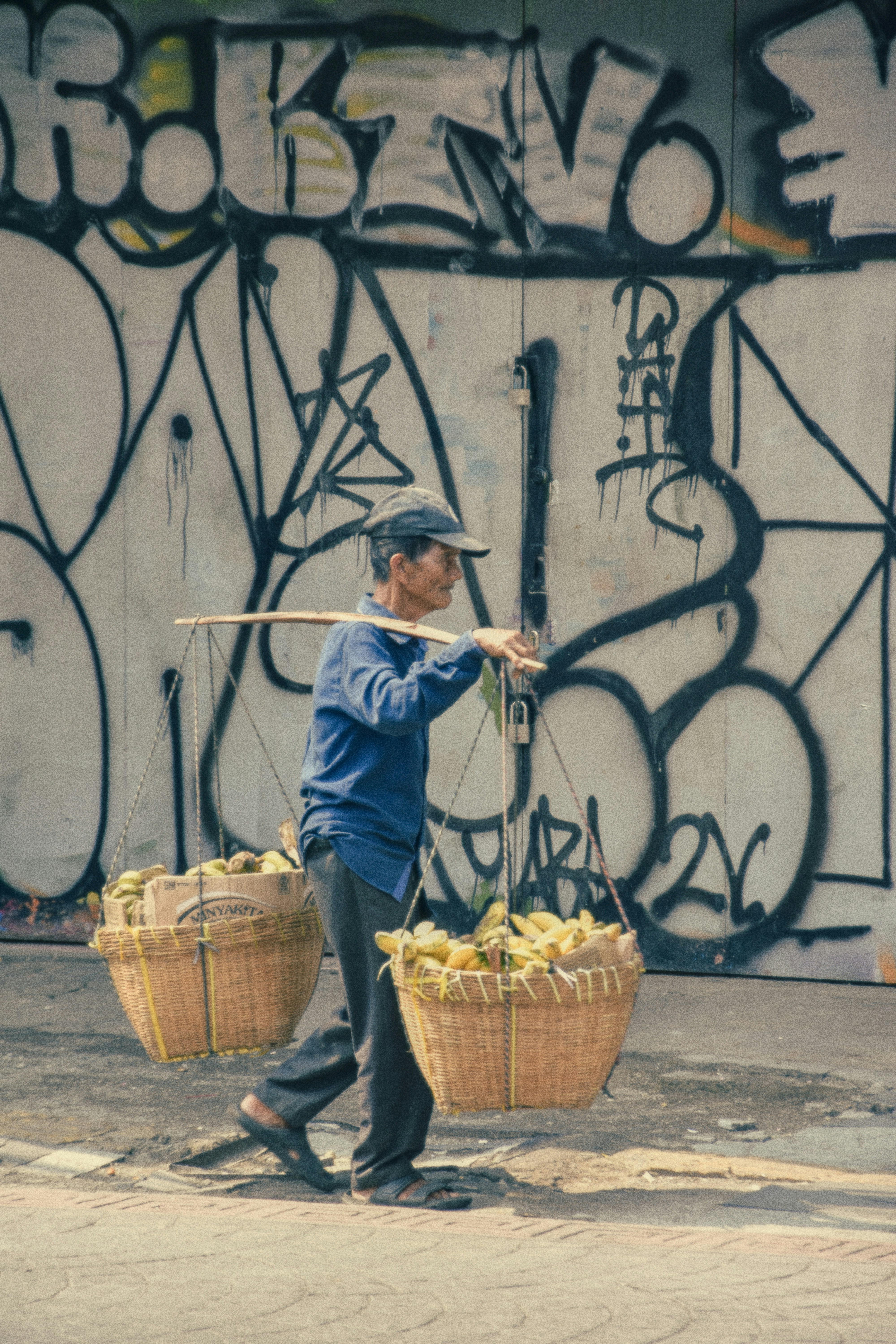 The Basket Carrier: Street Vendor Crossing Graffiti