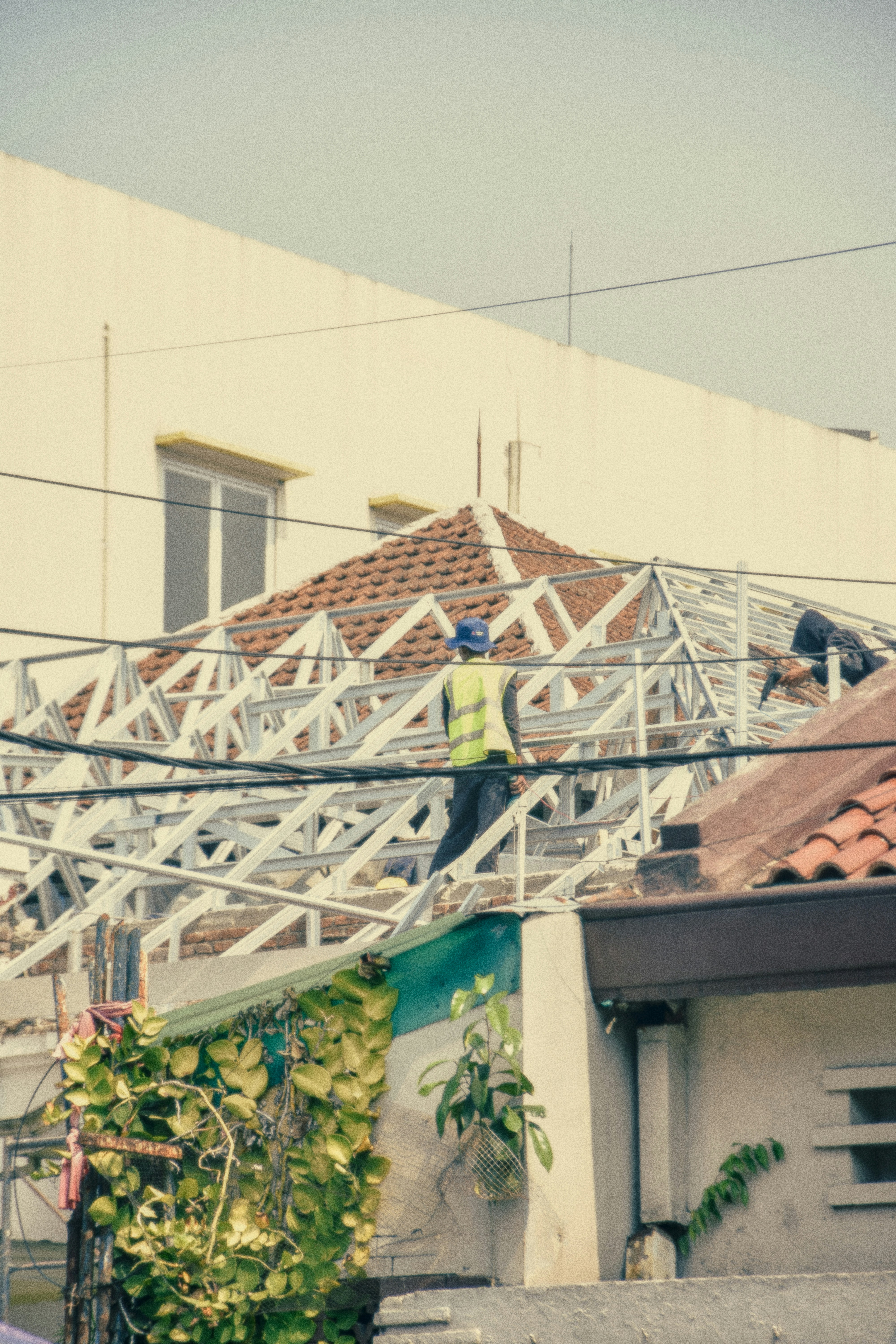 Roofing Relay: Construction Worker Amid Stark Lattice on a Sunlit Rooftop