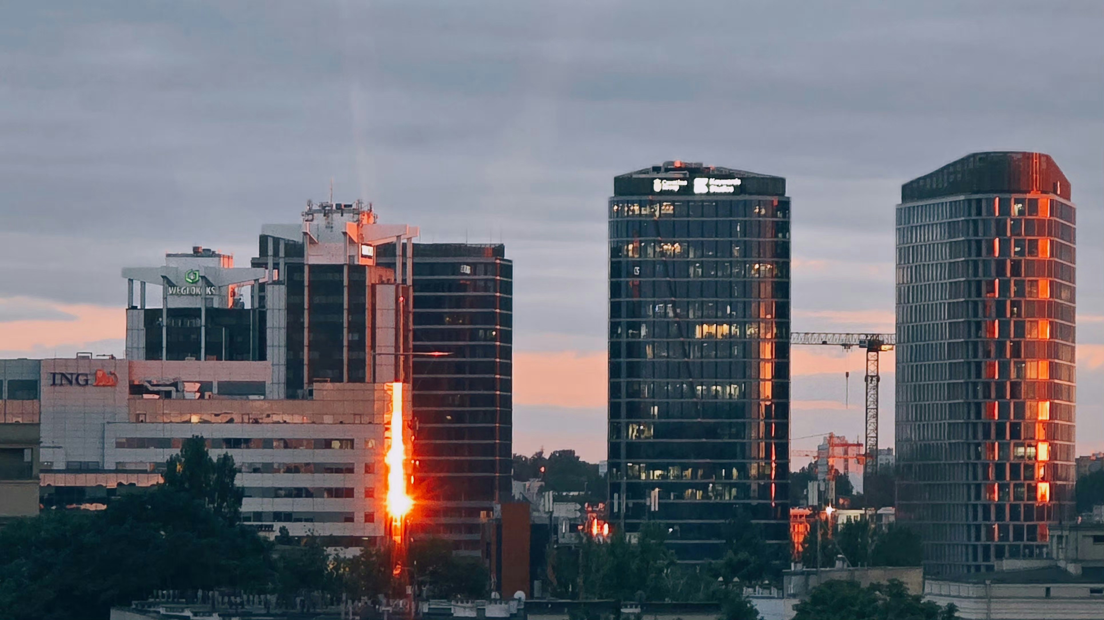 Rising Flames Above a Modern Cityscape at Dusk