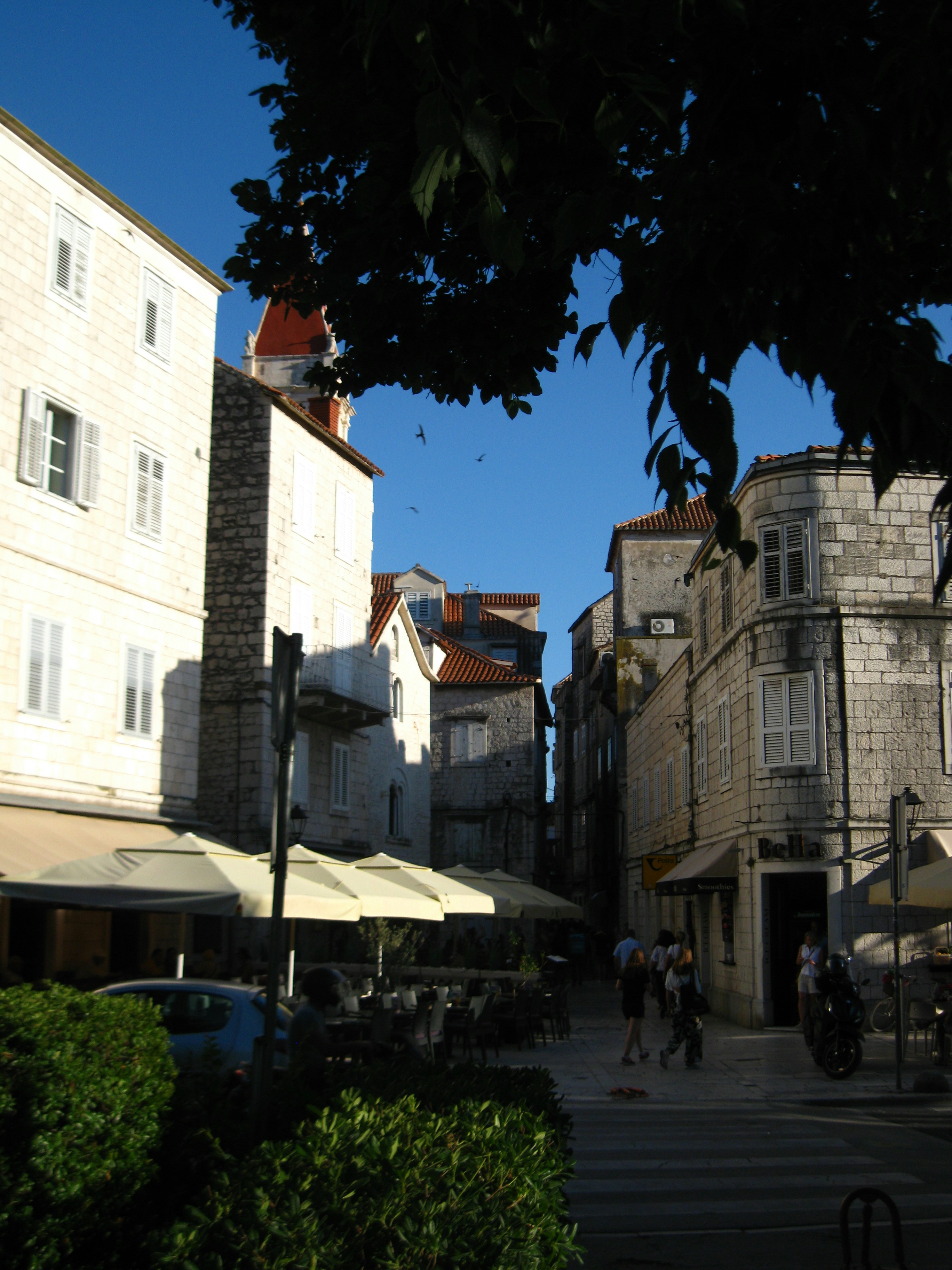 Sunlit Stone Street Framed by Canopy and Shadowed Facades