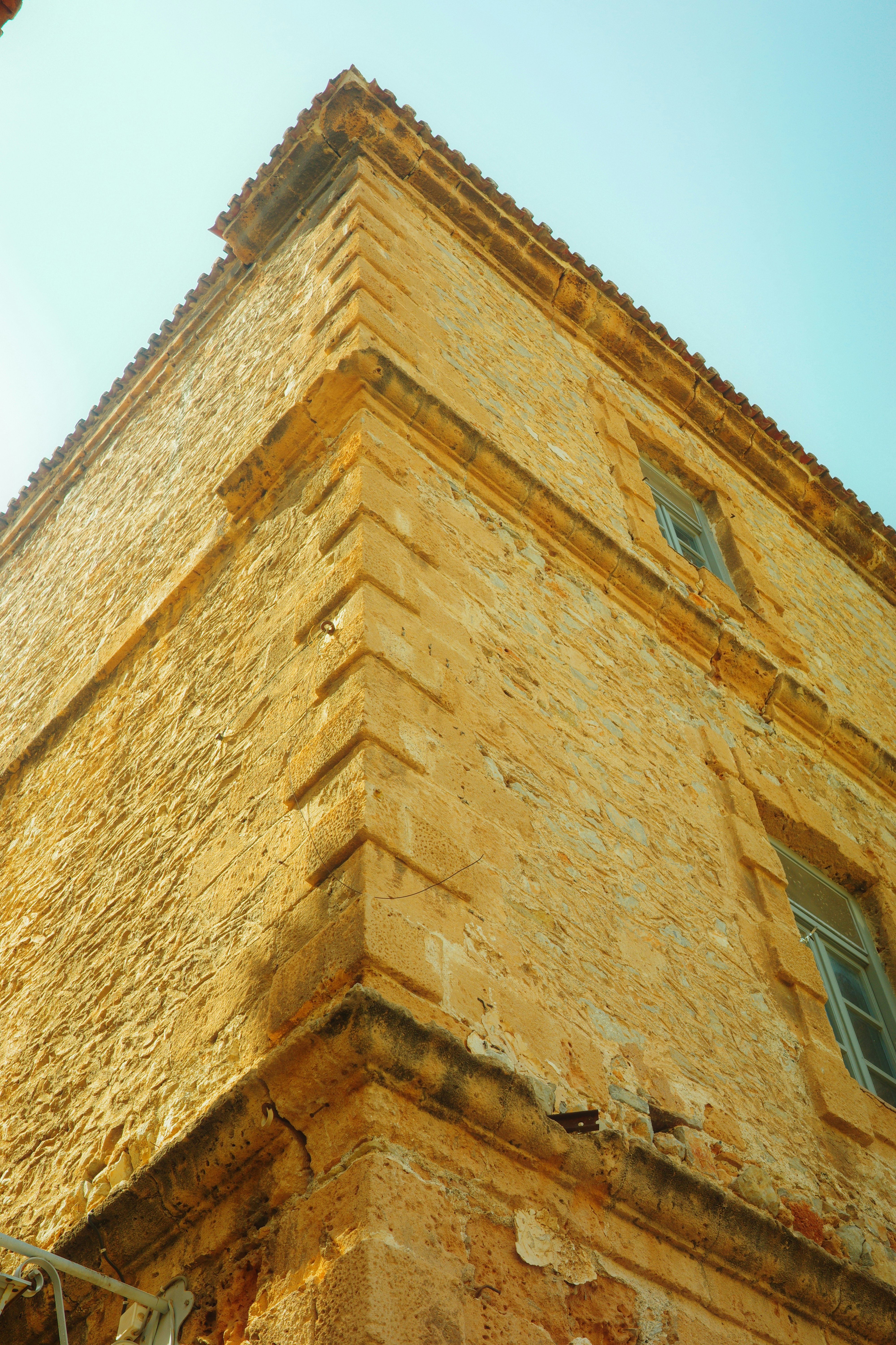 Angular Facade: A Sunlit Corner of Weathered Stone