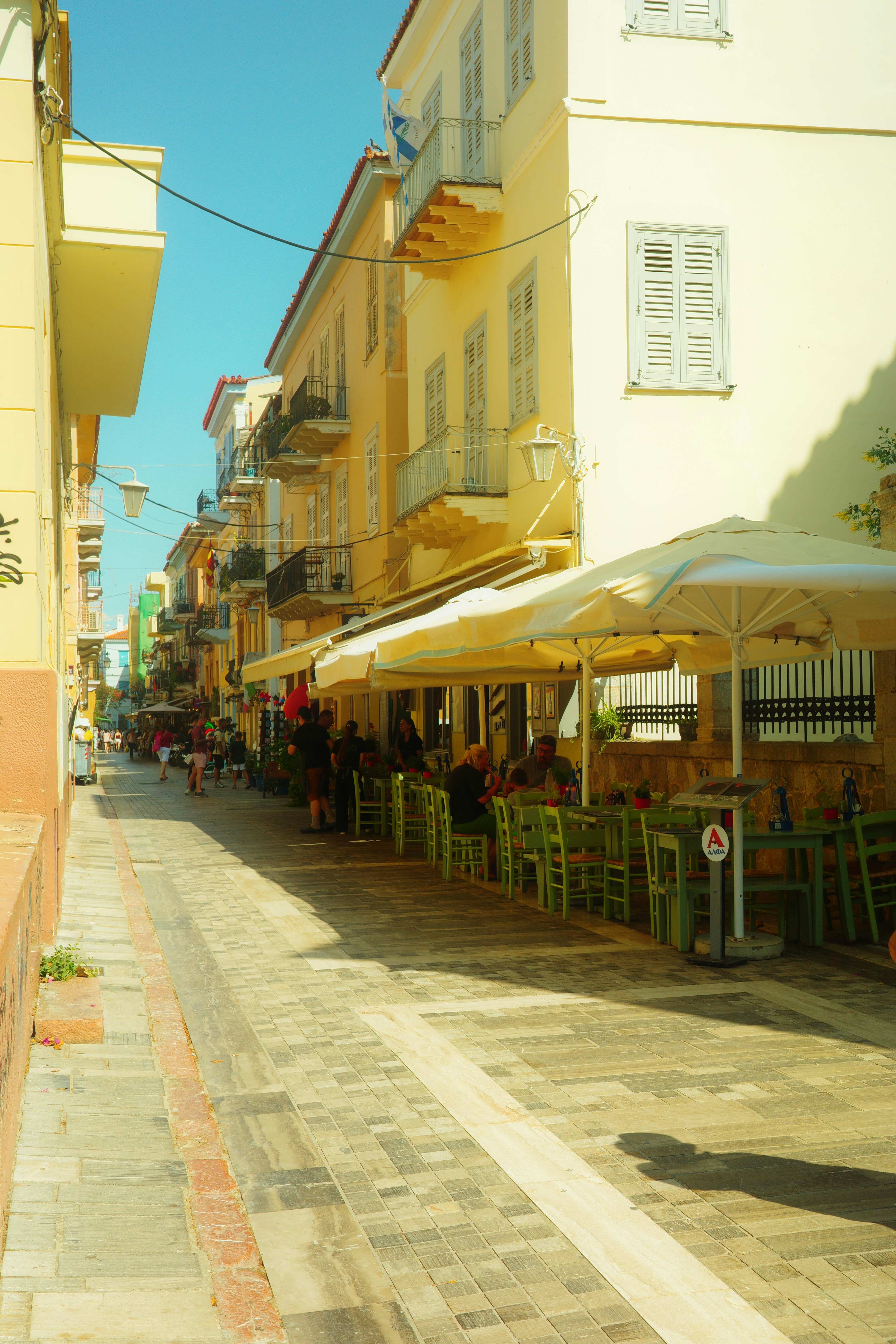 Sunny Street Café Under Yellow Balconies