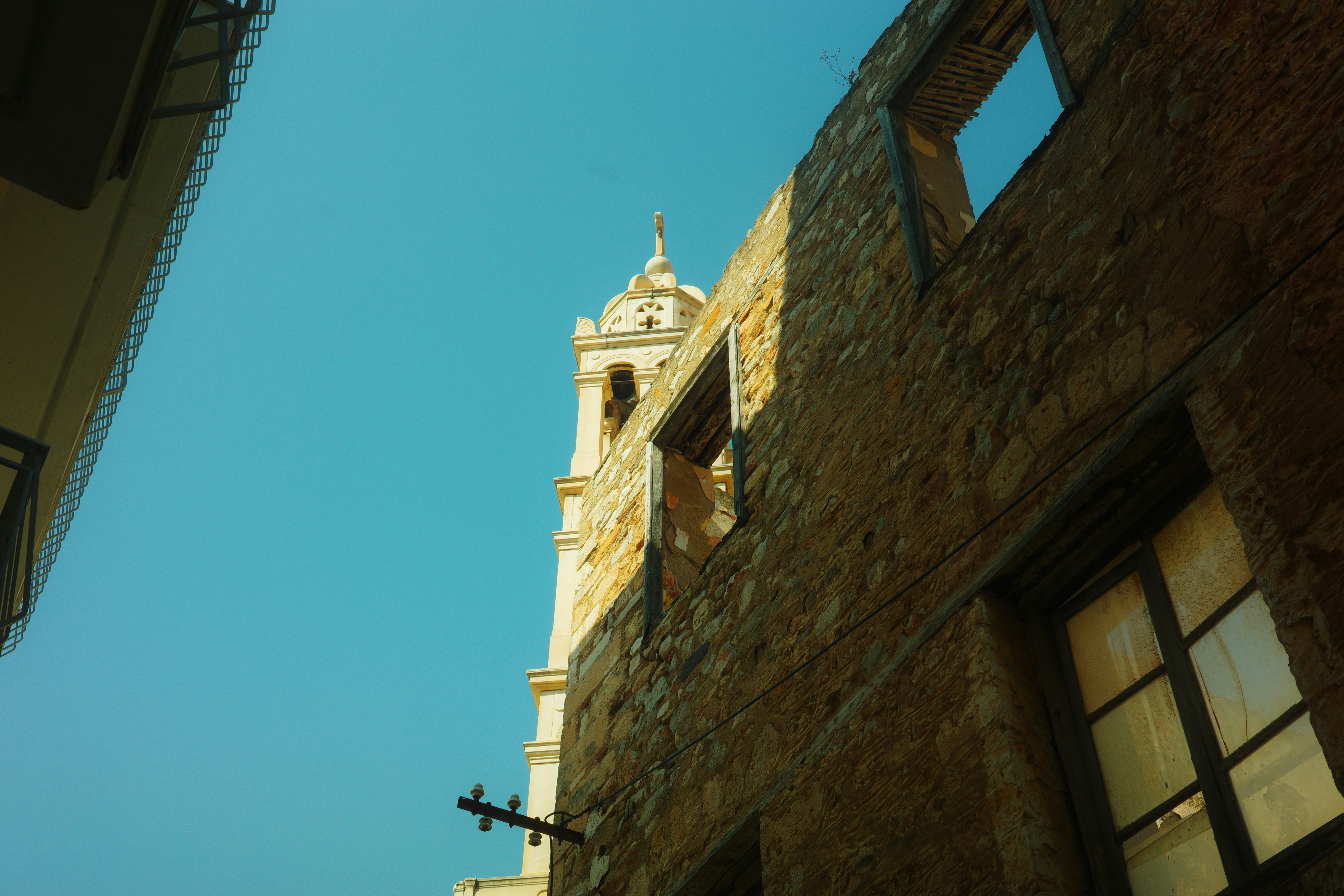 Towered Brick Quiet: Sunlit Facade Against a Clear Blue Sky